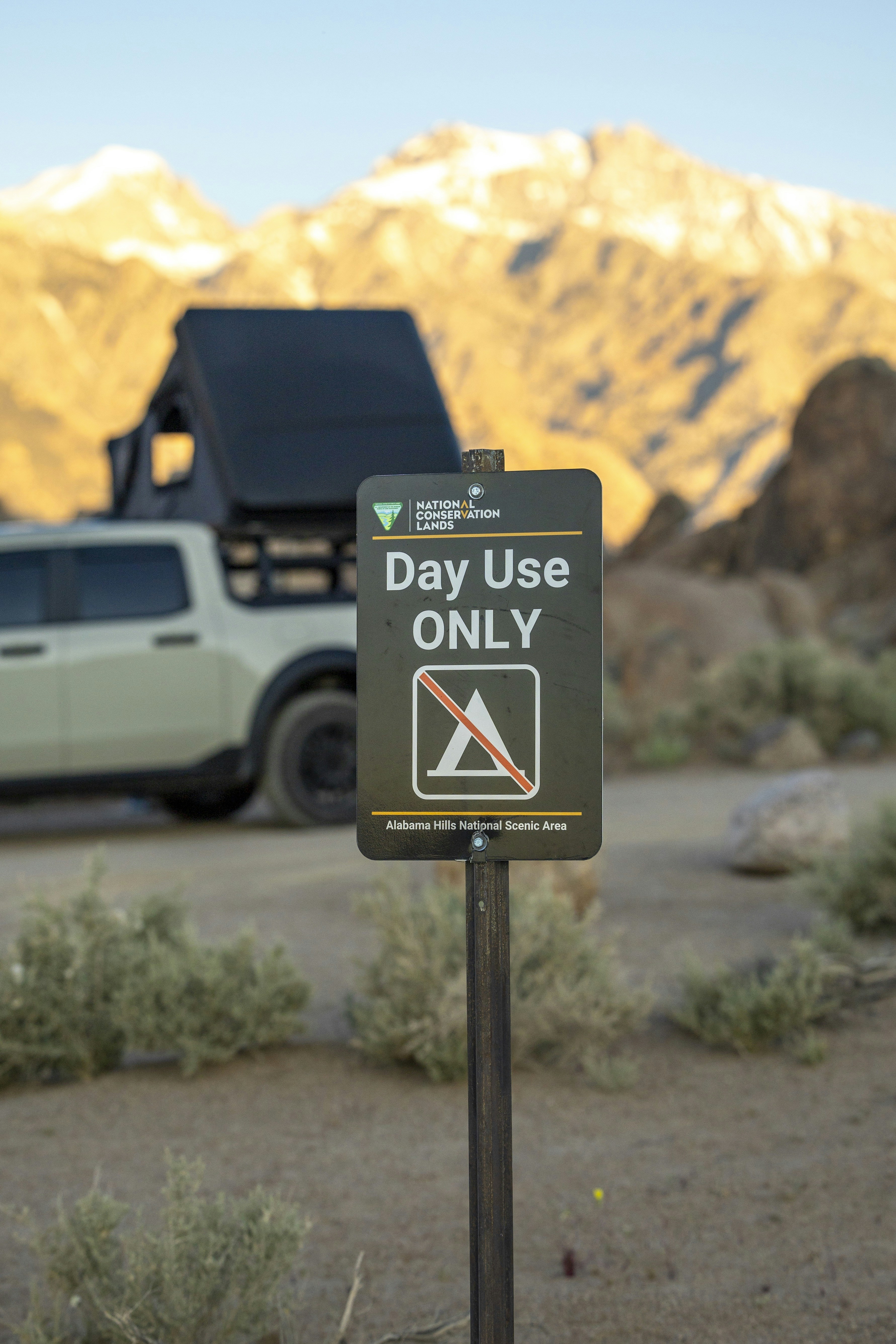 Day-Use Signpost in a Desert Landscape with Mountain Backdrop