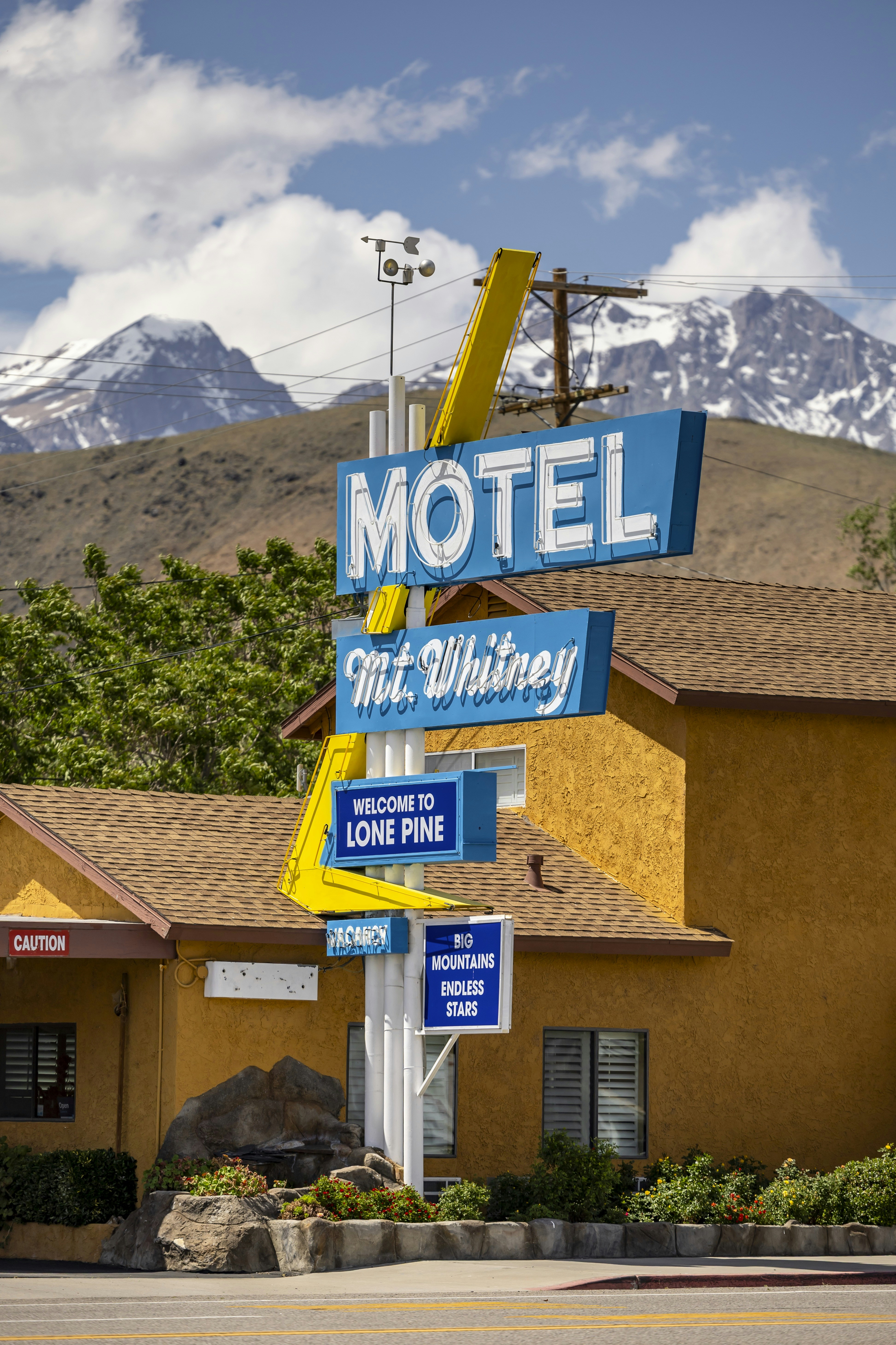 Neon Motel Sign Amid Mountain Backdrop