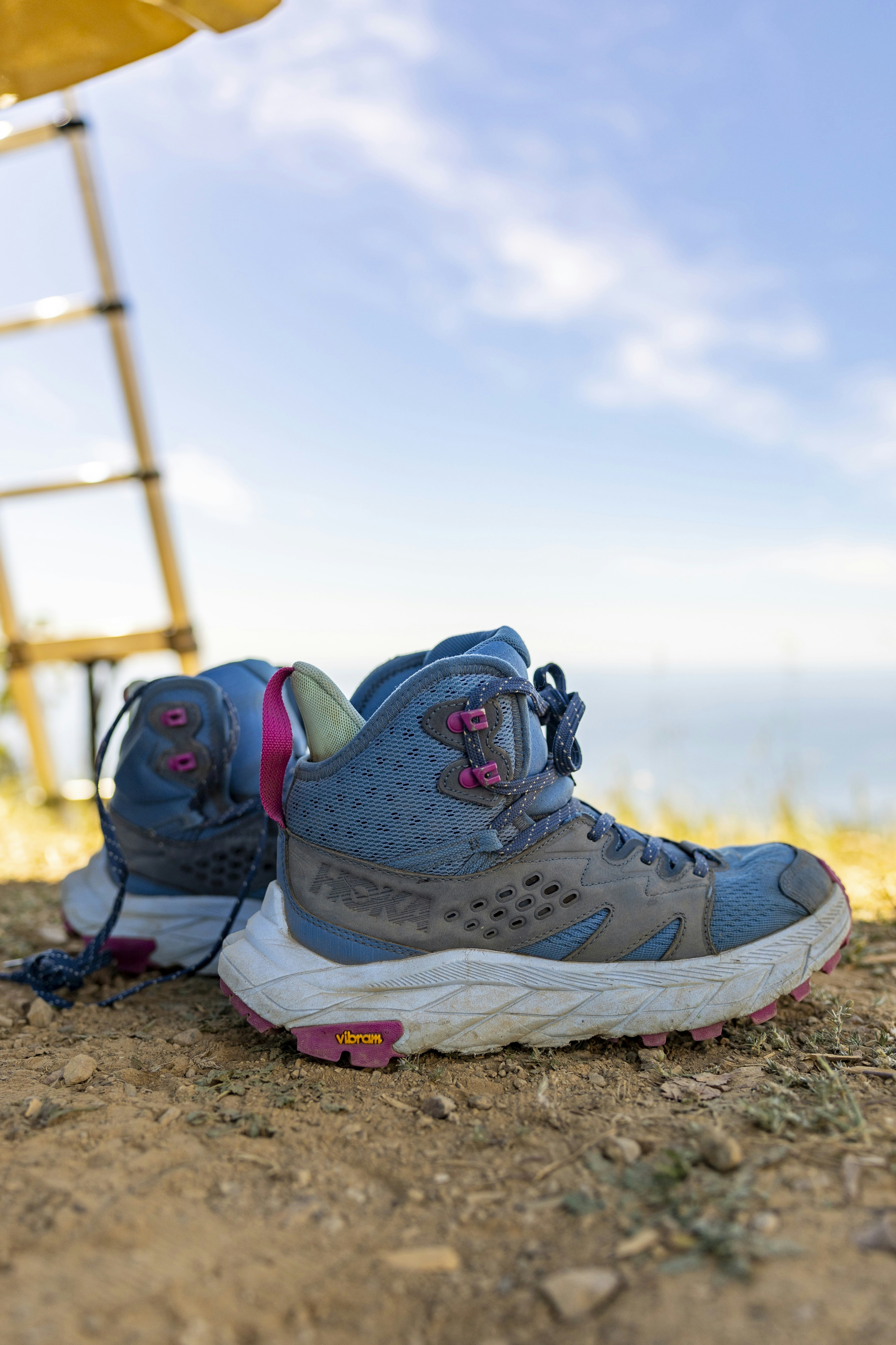 Worn Blue Trail Runners Resting on Gravel Overlook
