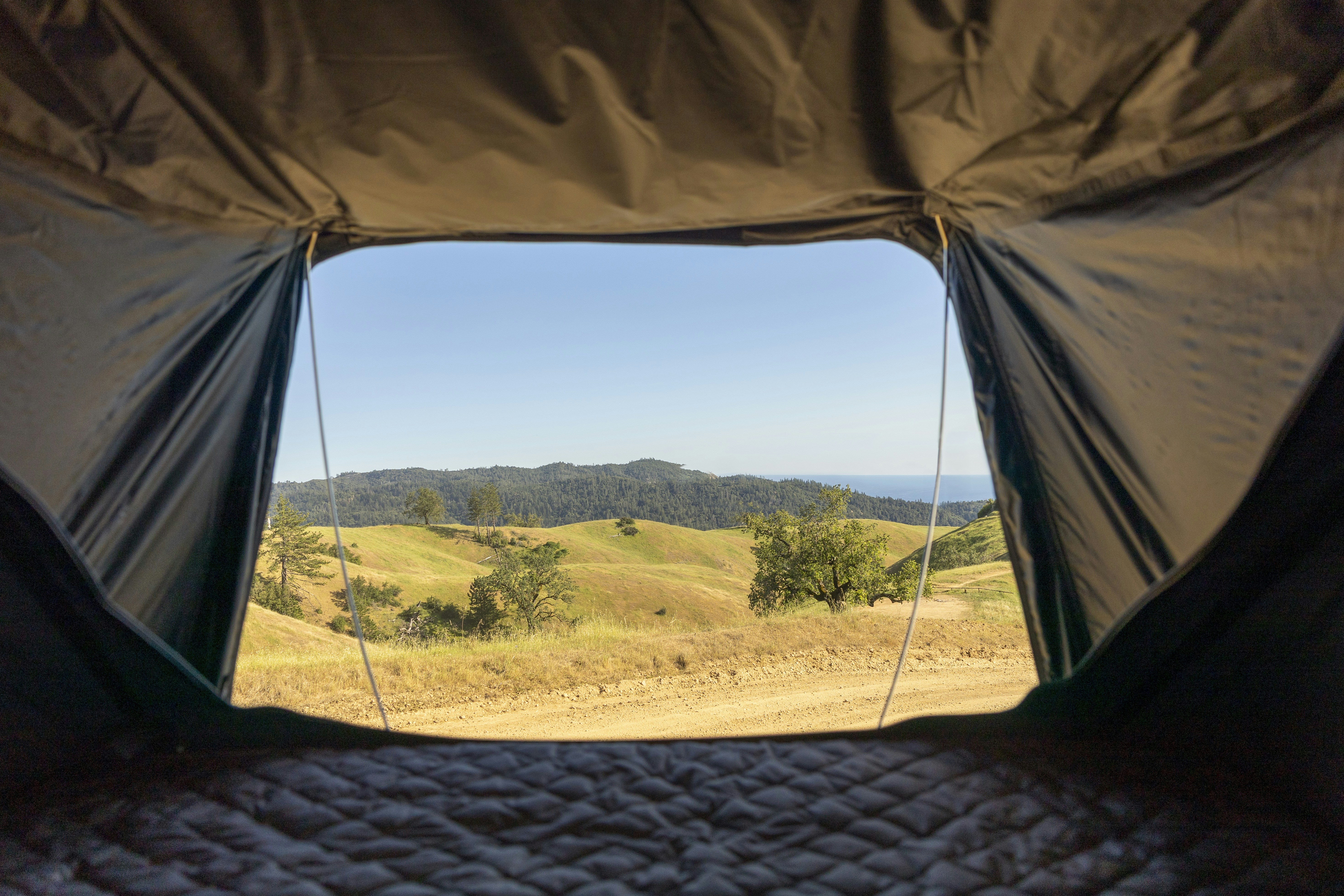 Horizon Awakened: Sunset through a Tent Vista