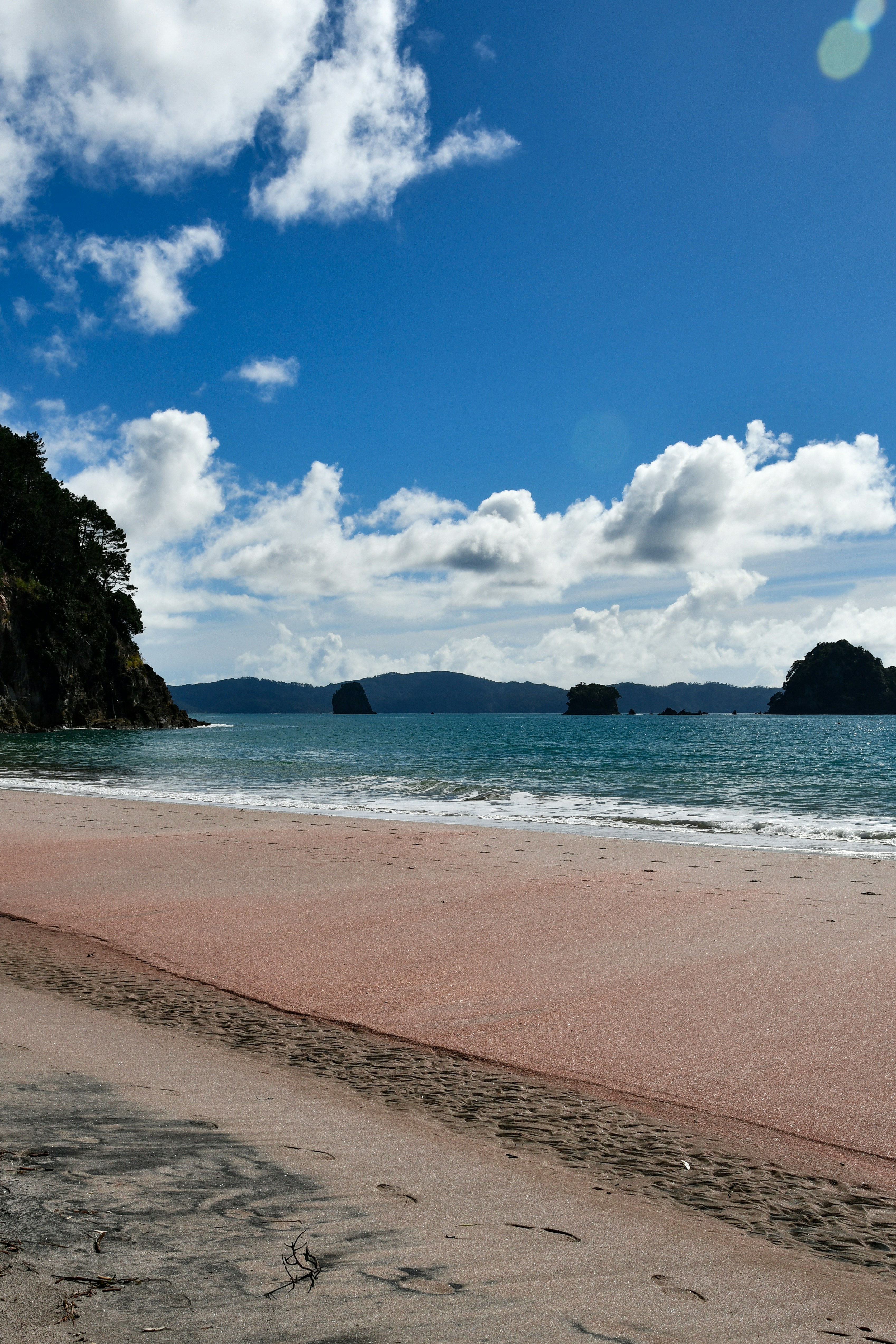 Pink Sand Shoreline Beneath a Wide Blue Sky