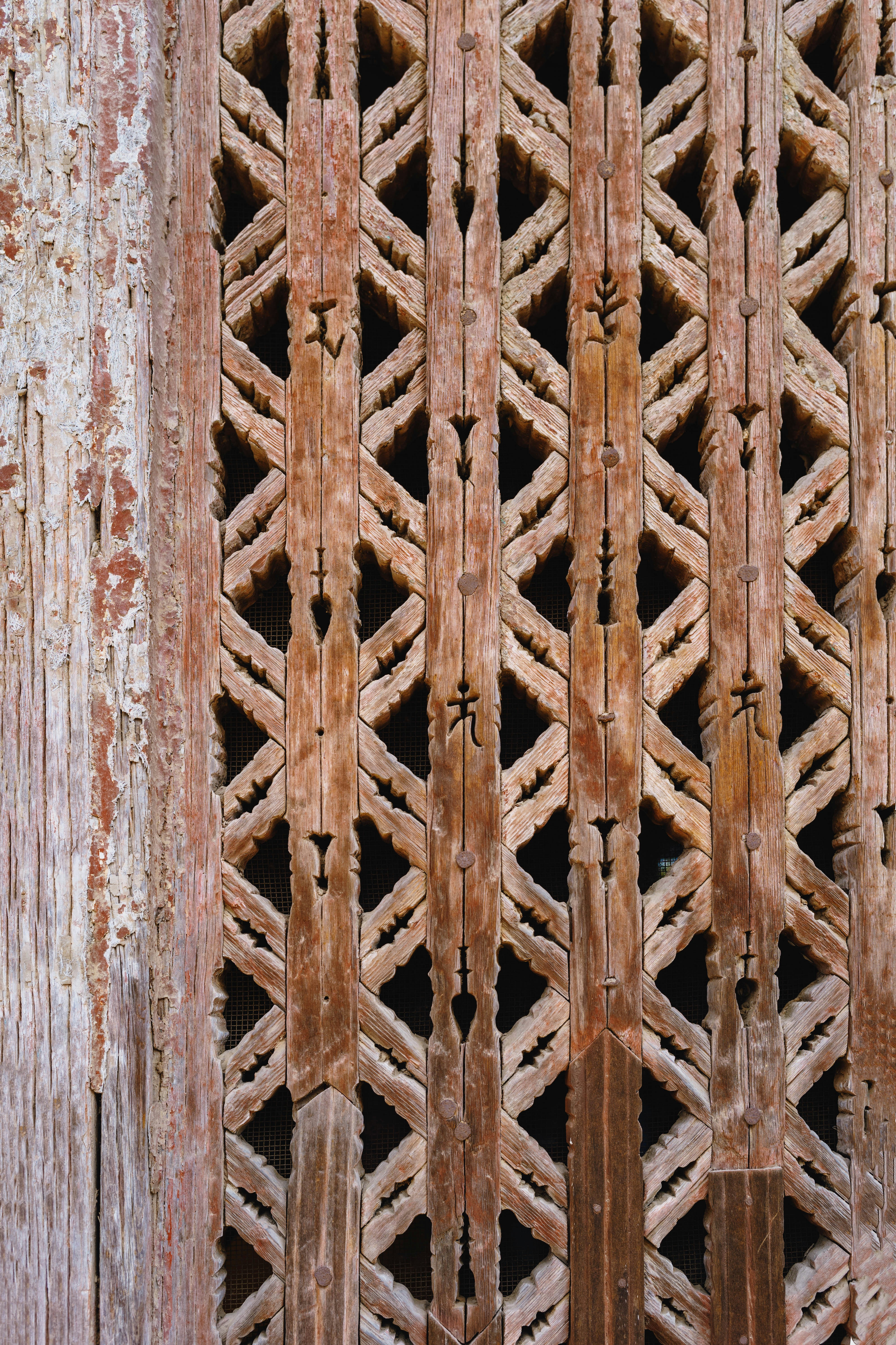 Rust and Ridges: Carved Lattice Door Texture in Weathered Wood