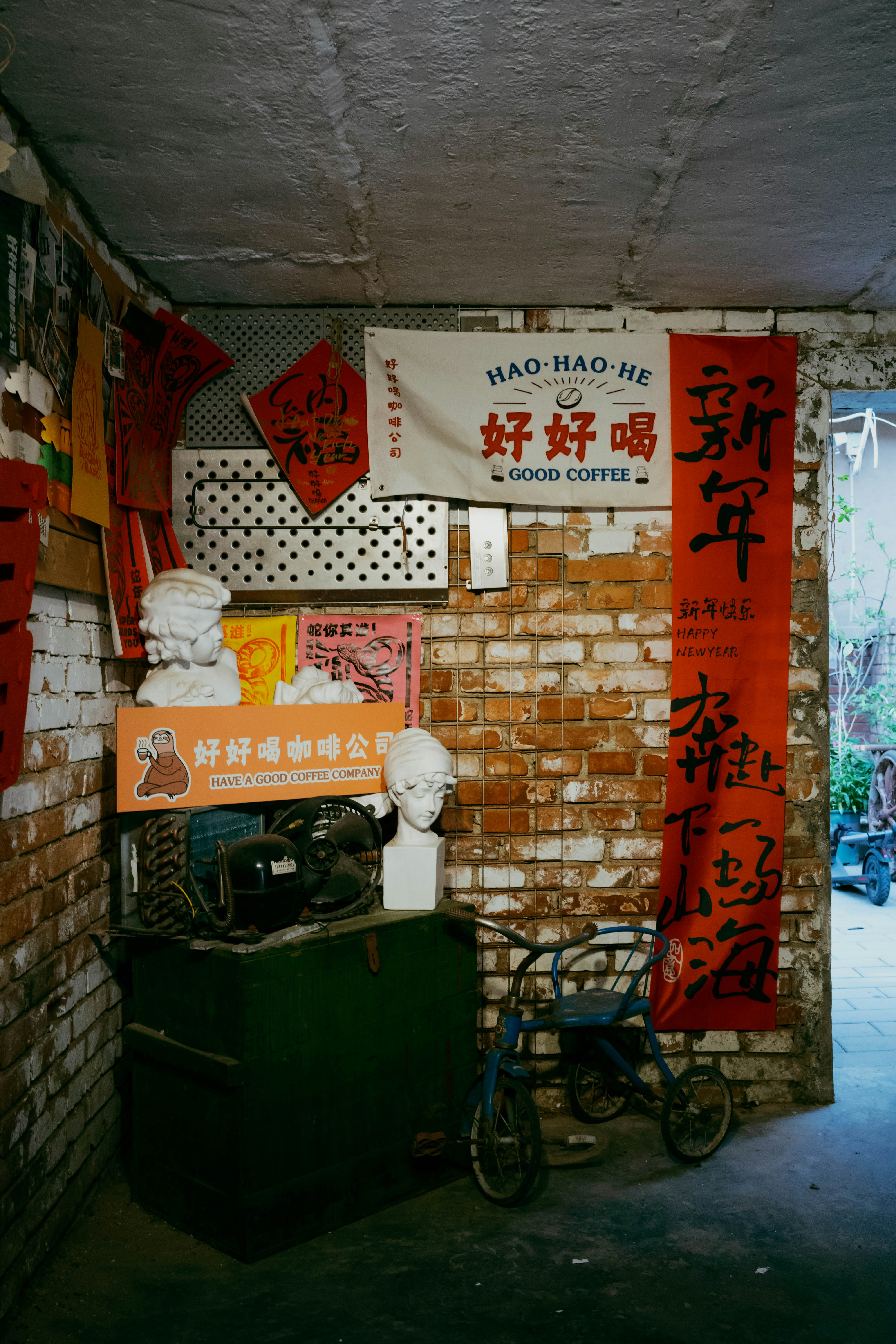 Brick Corner Coffee Shrine: Vintage Signage and Sculptures in a Narrow Workshop