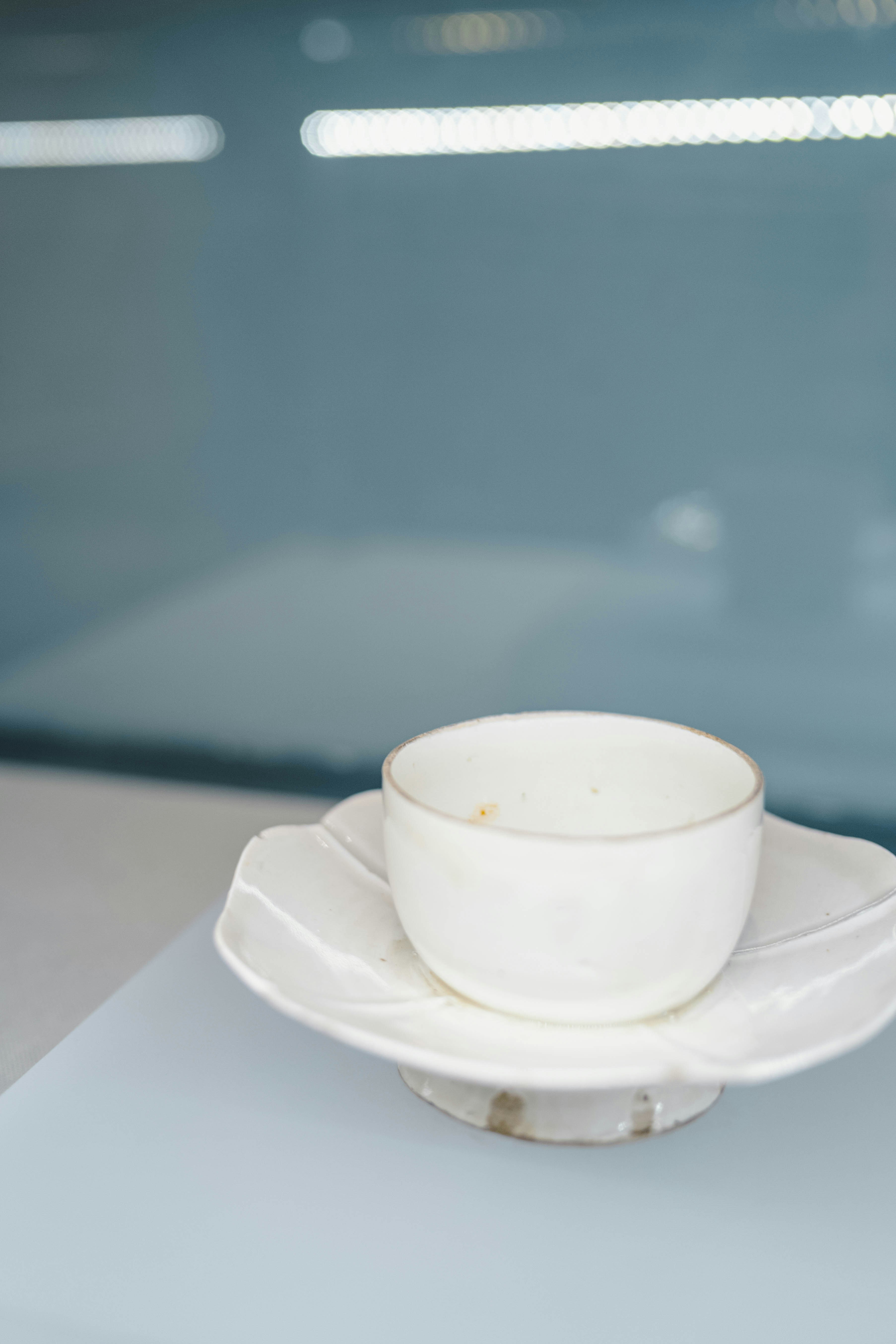 Soup Cup on a Spooned Saucer Under Soft Studio Light