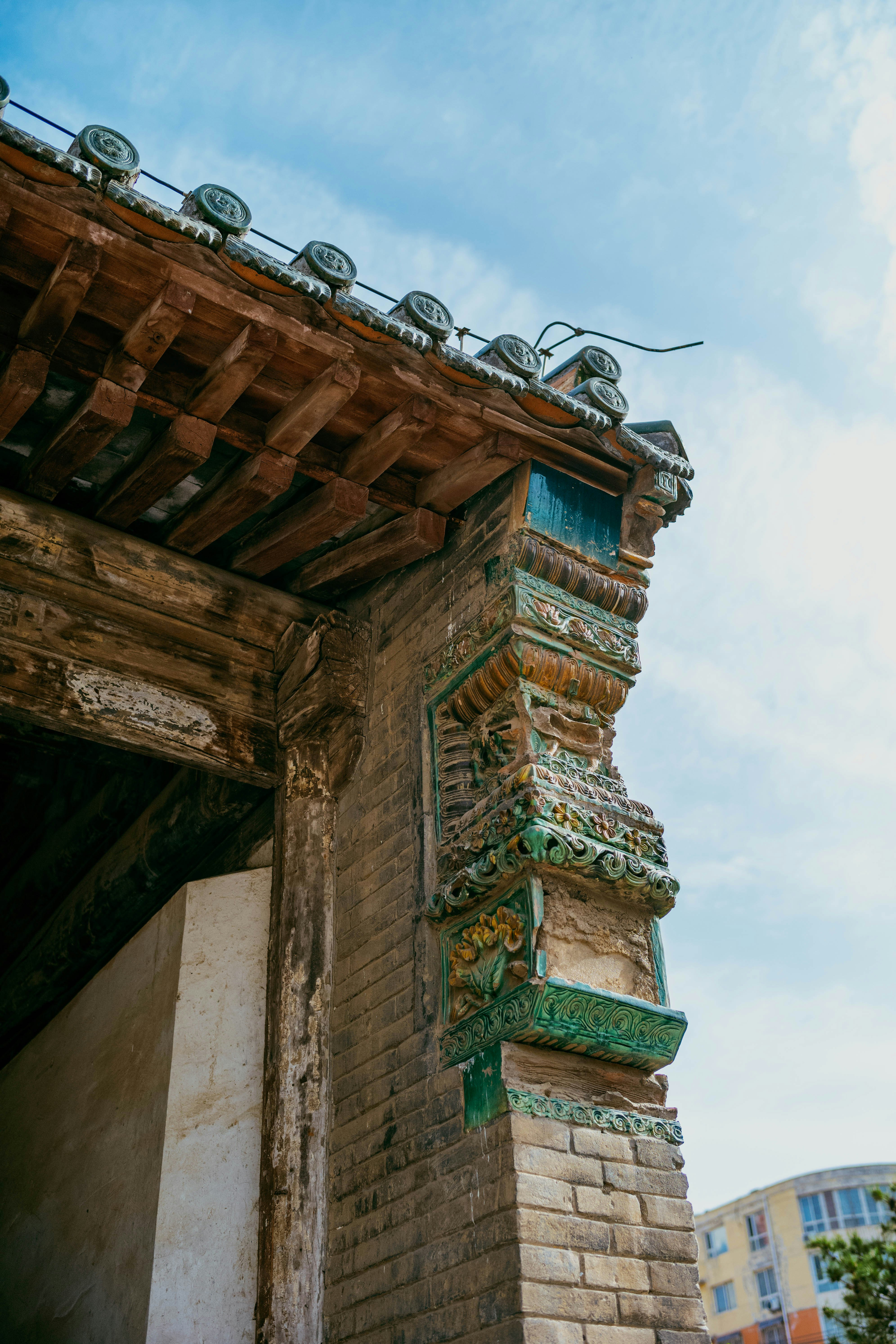 Weathered eave carvings of a temple catch the afternoon light