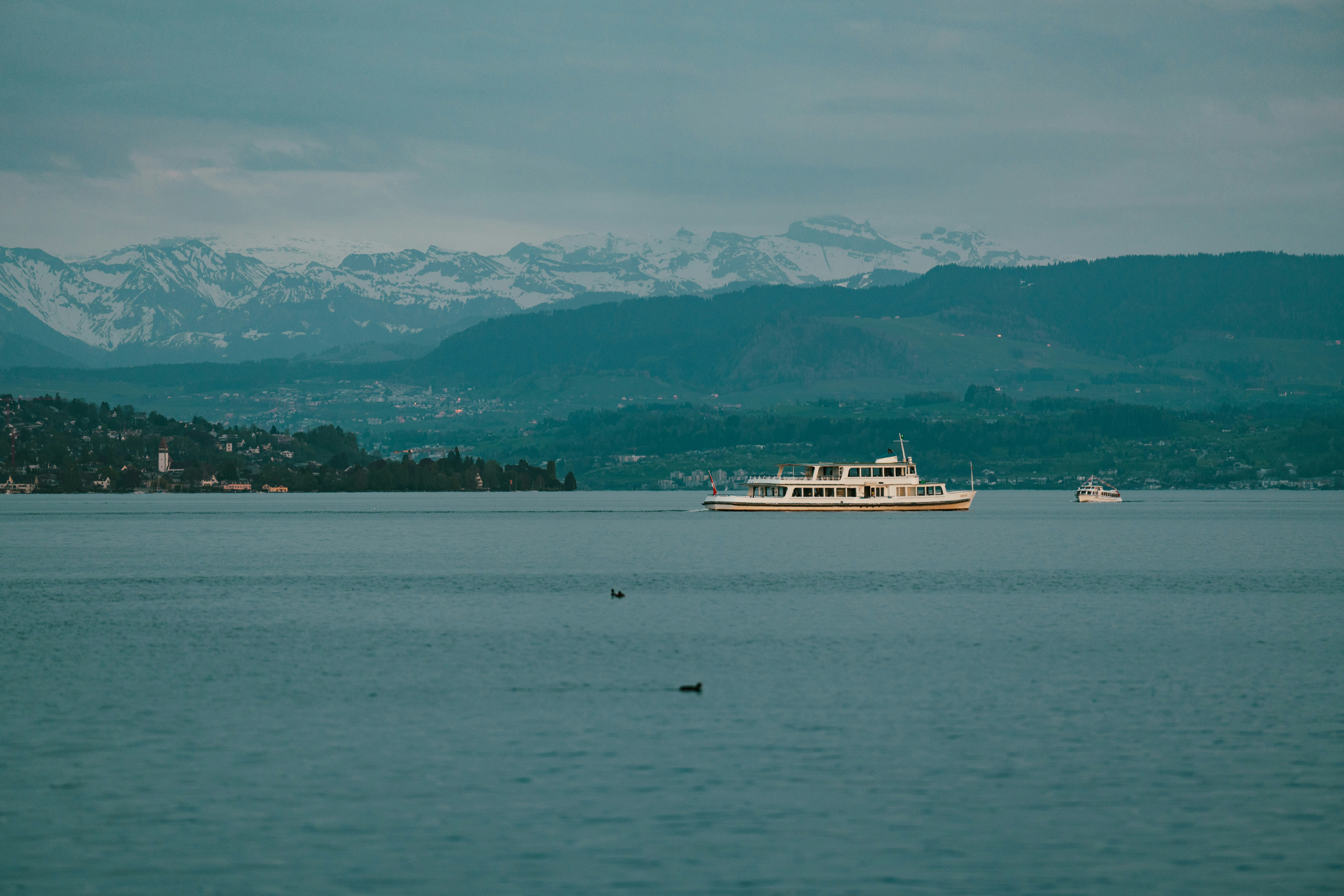 Midday Ferry Gliding Across a Mountain-Backed Lake