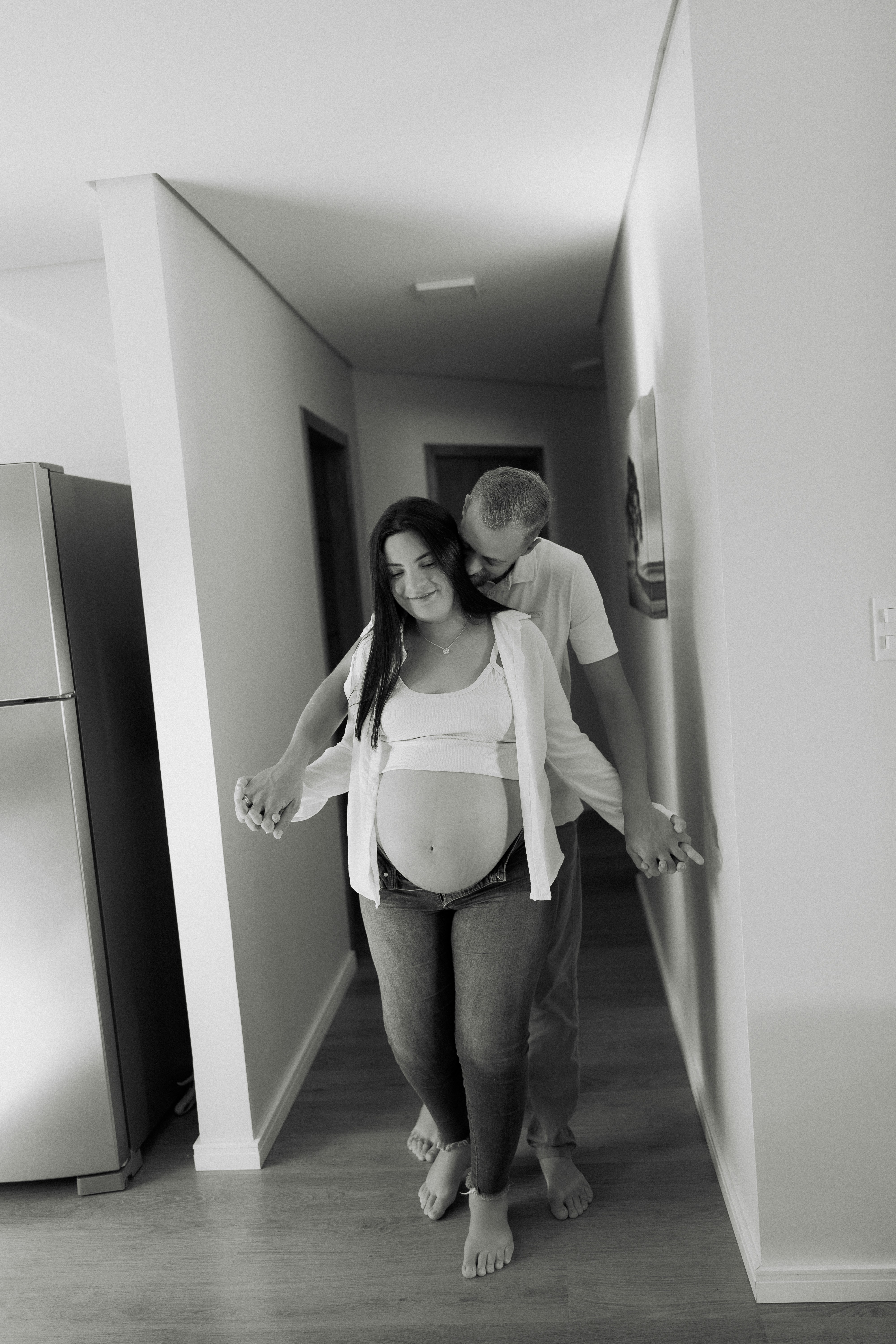 Pregnant Moment: A Couple Walks Hand in Hand Through a Quiet Corridor