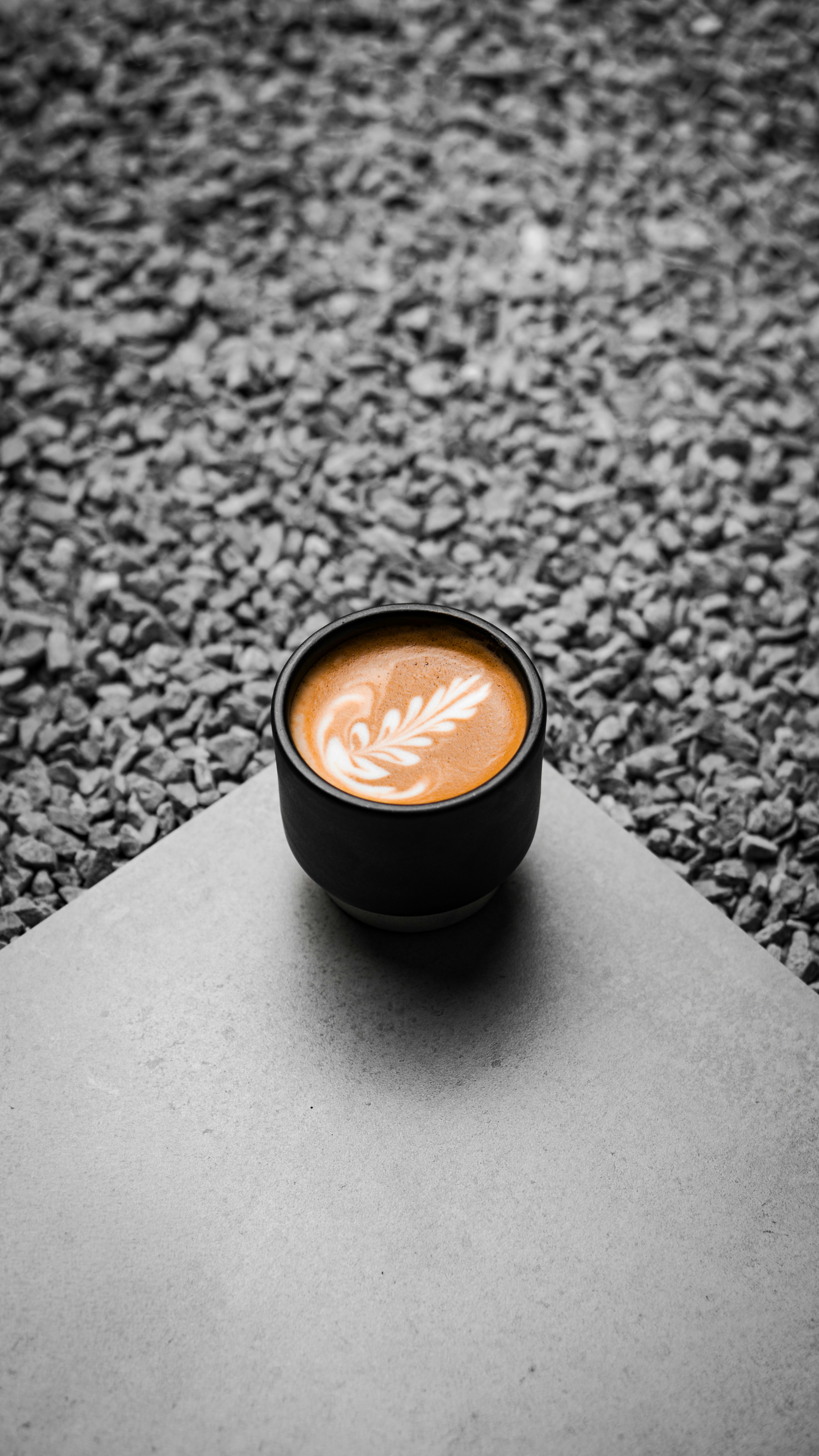 Centered warmth: a solitary latte on a concrete pedestal