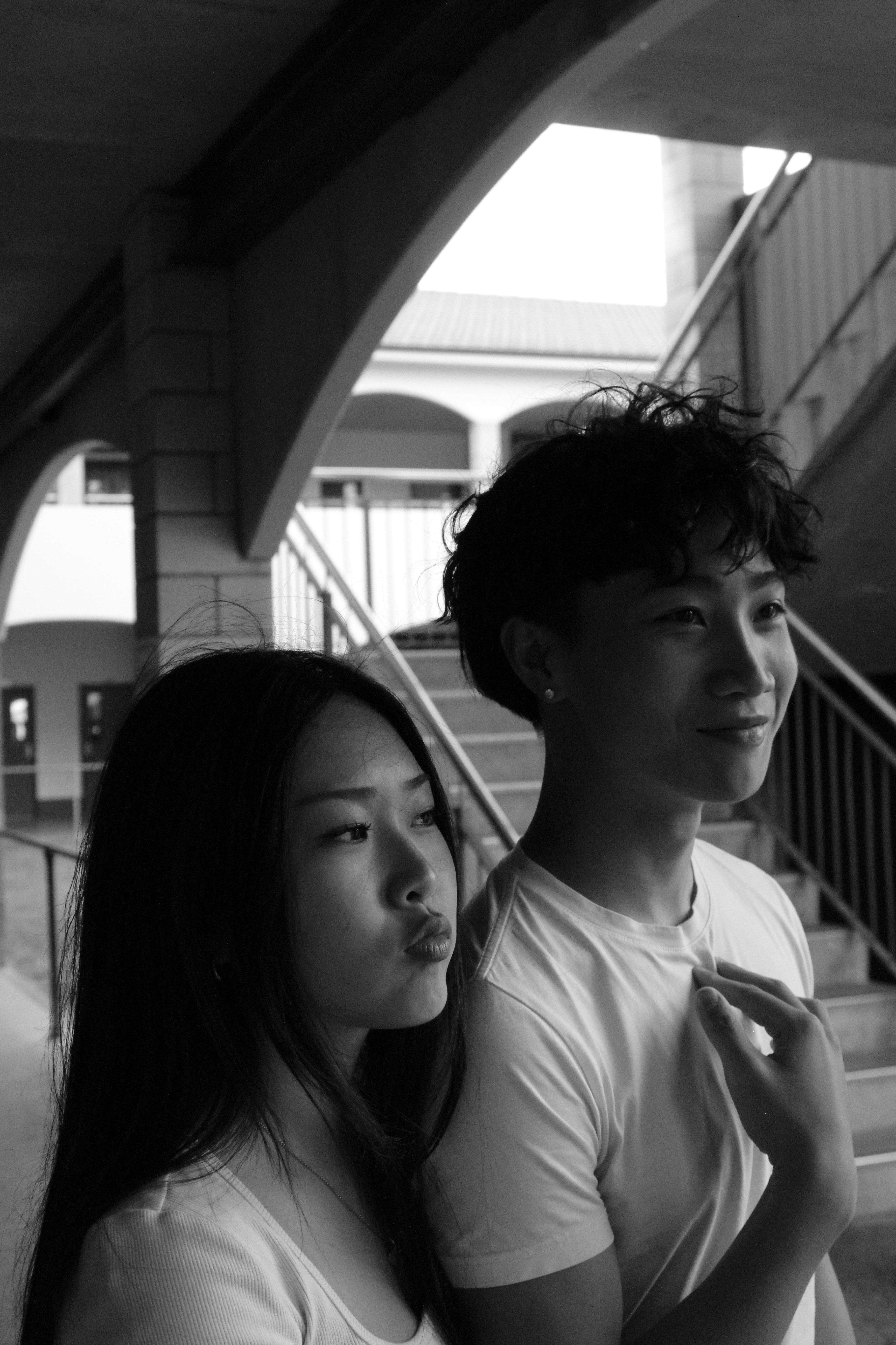 Smiles in the Shade: Two Friends under Archway Light