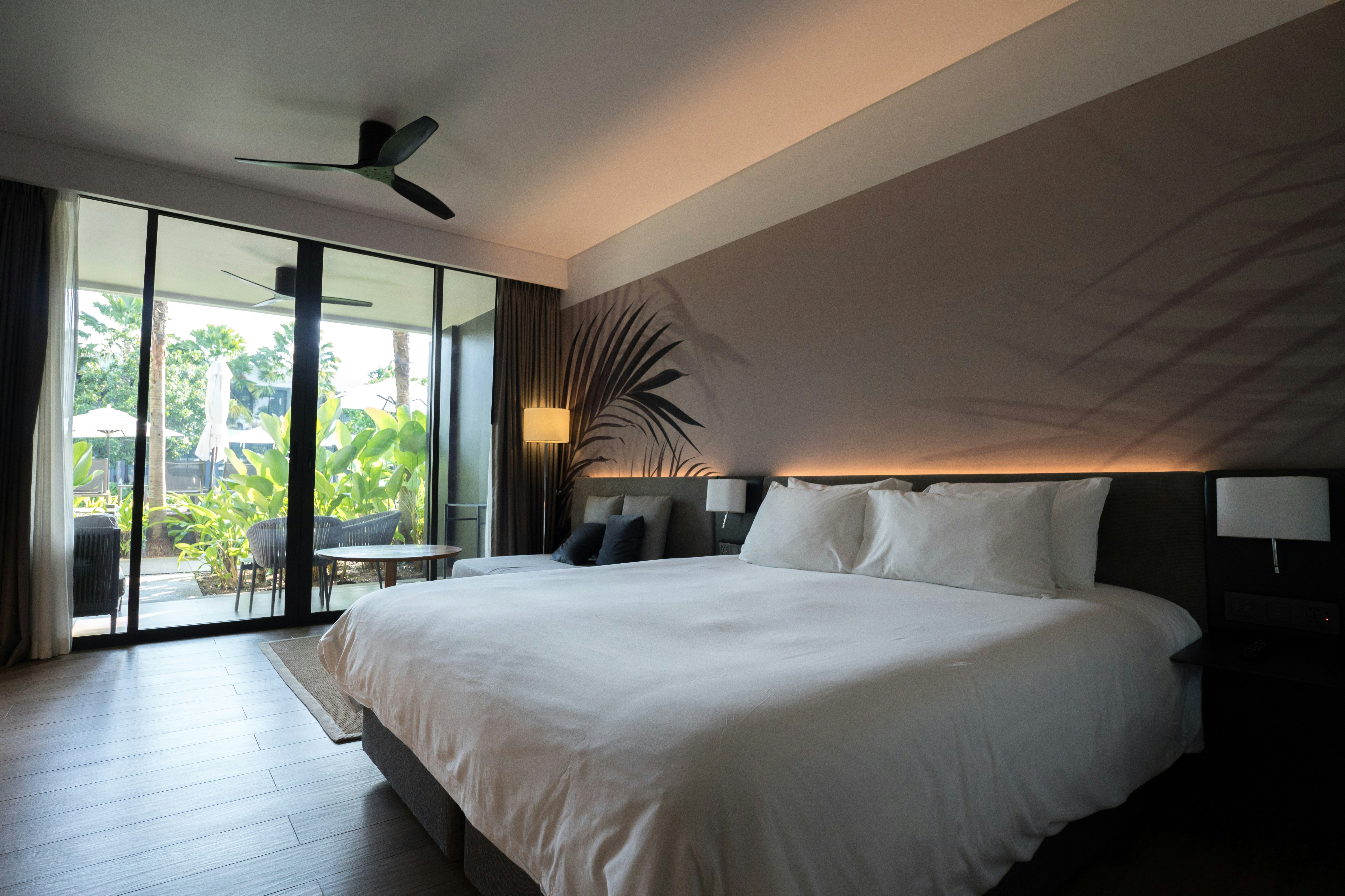 Hotel Suite at Dusk: Bedside Glow and Glass Balcony View