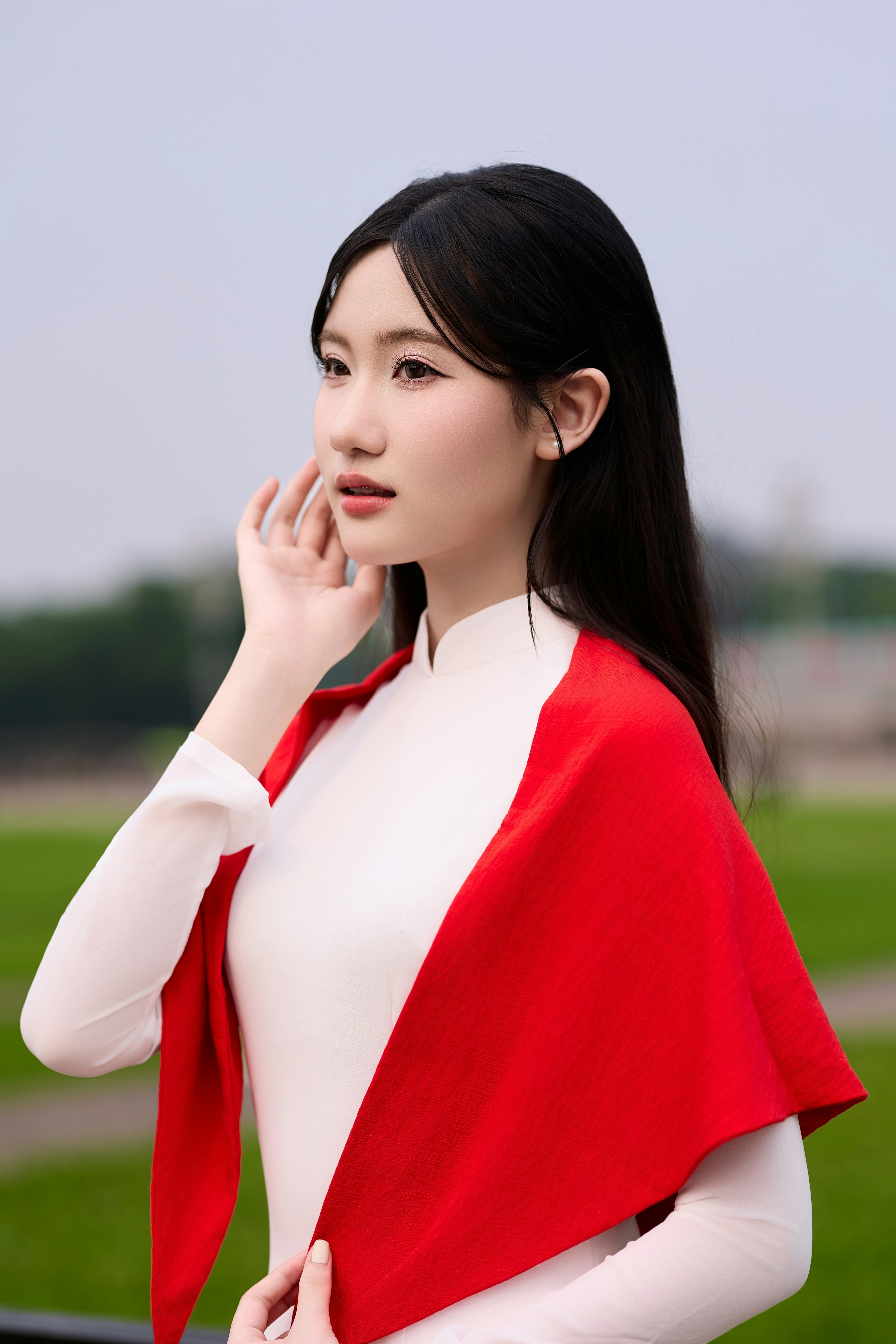 Red shawl, soft light, poised gaze