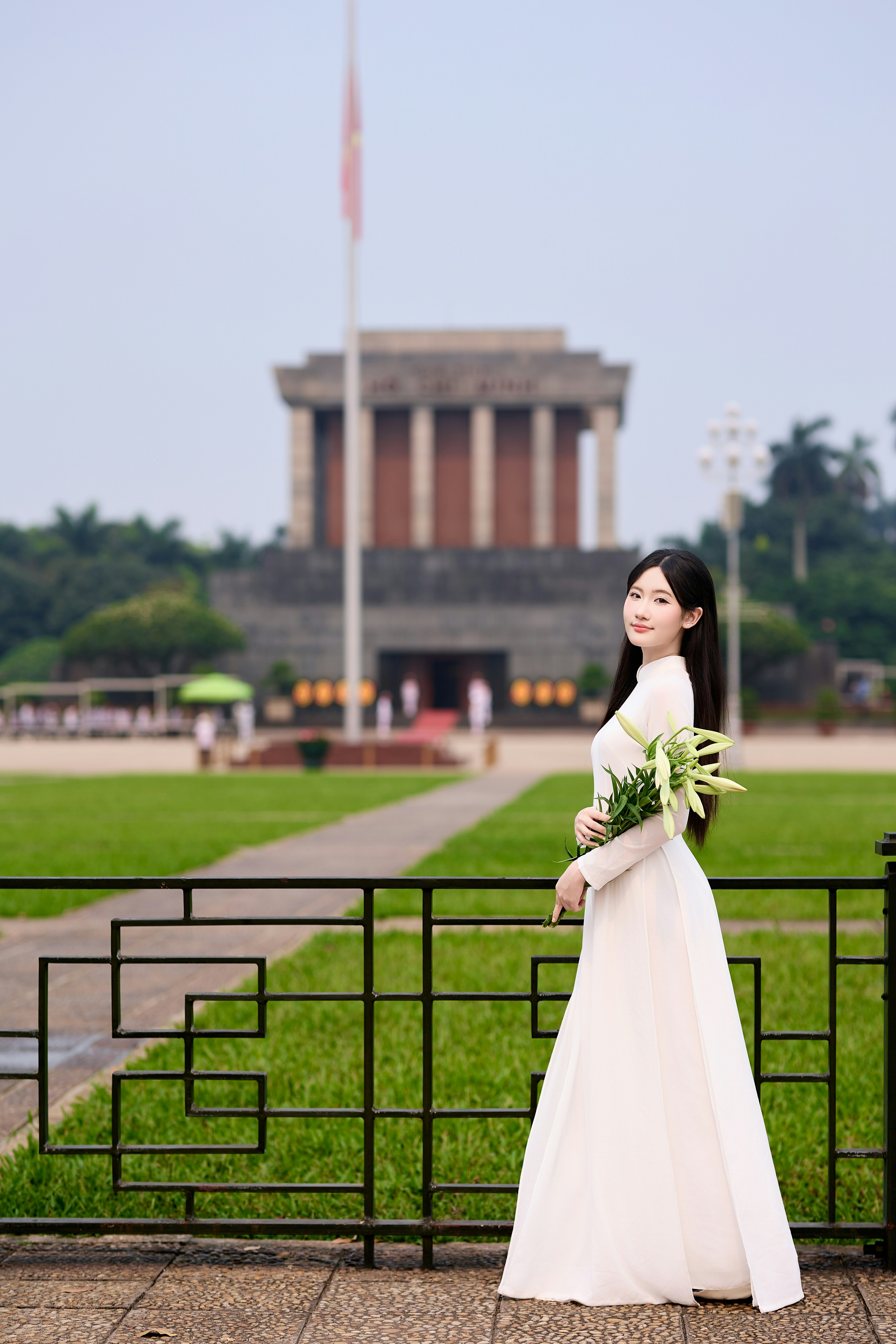 Bride in White at the Gate: Quiet Grace Before a Monument