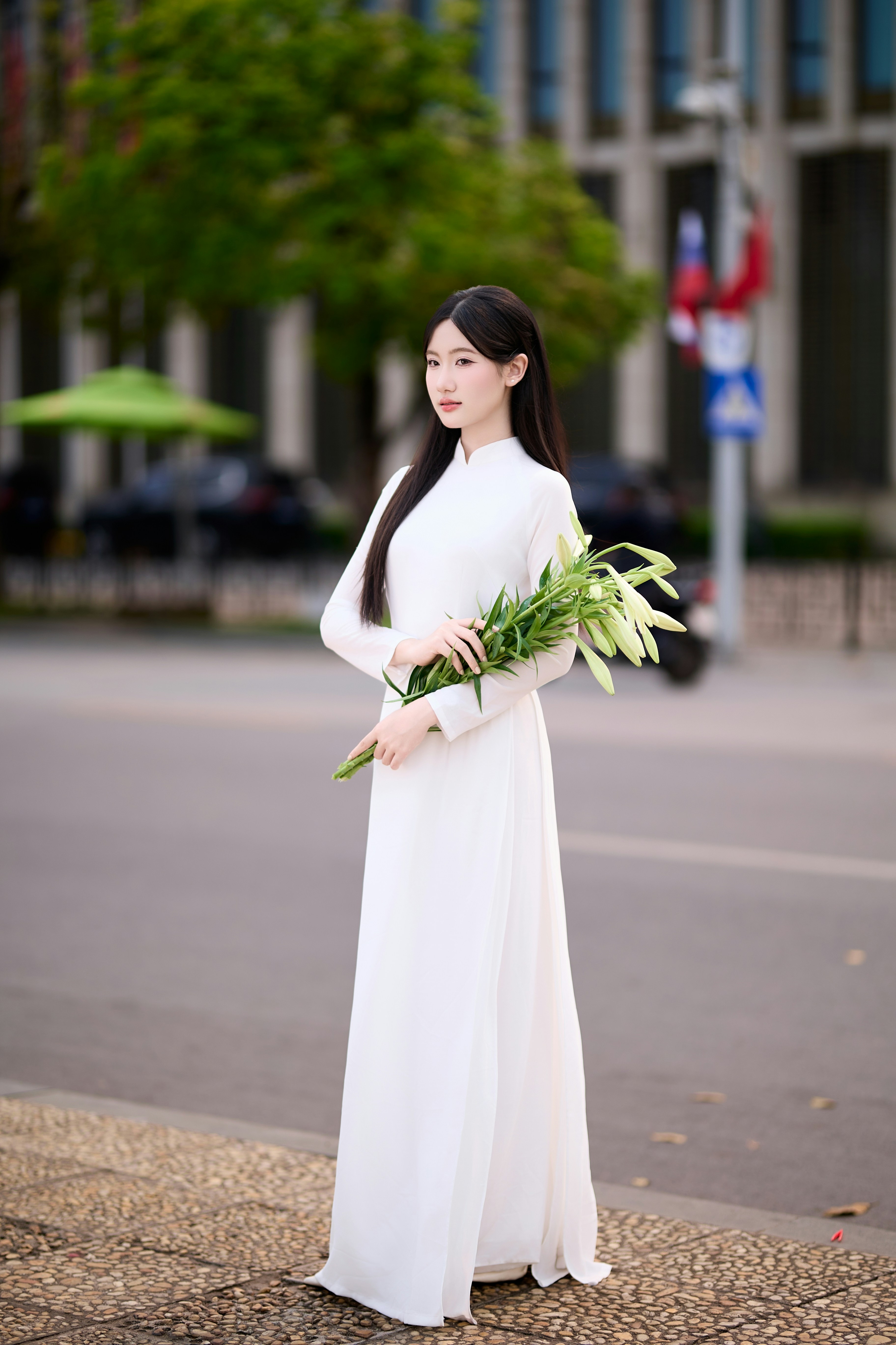 Elegance in White: A poised portrait on a city street