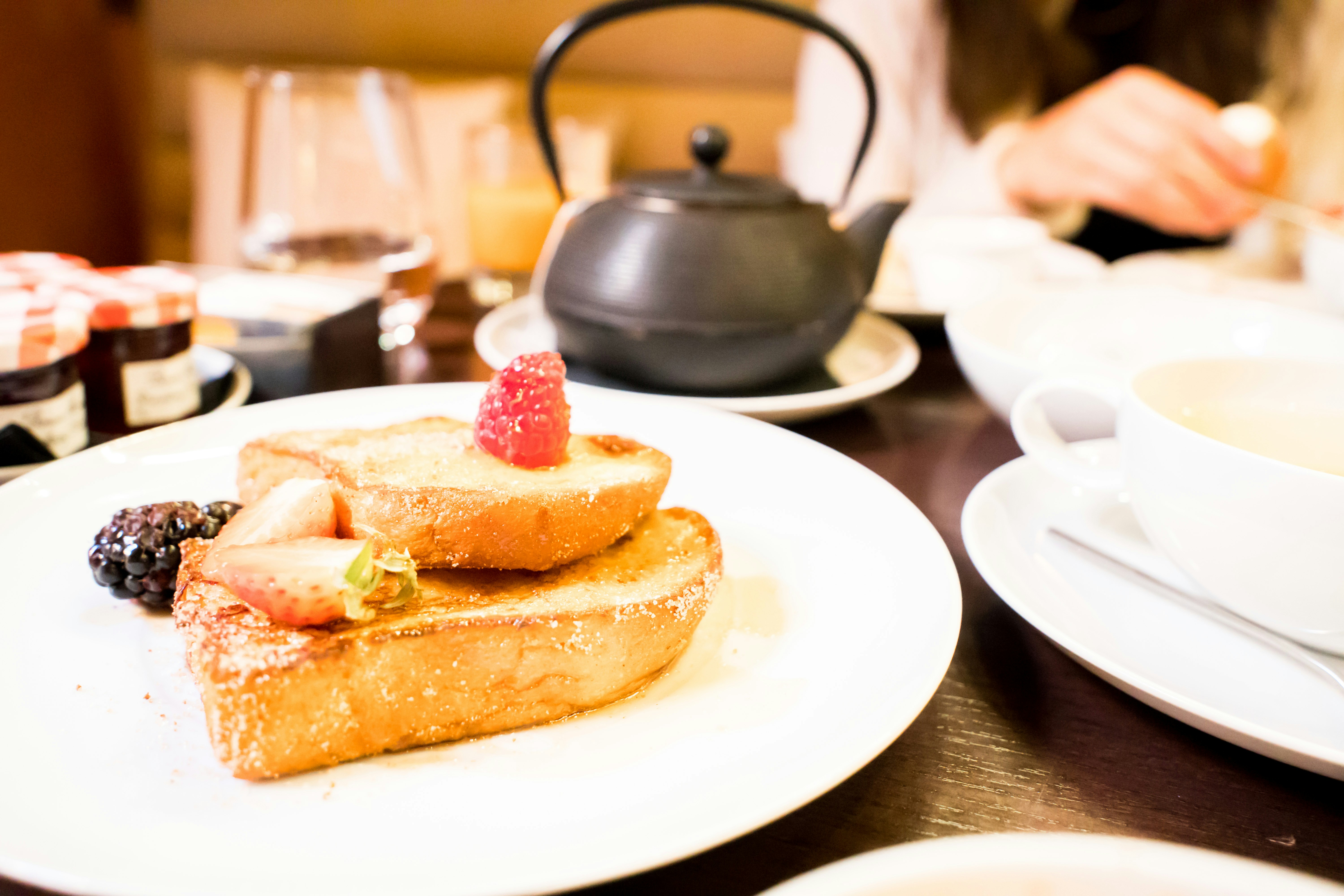 Raspberry-topped French Toast Trio on a Busy Breakfast Table