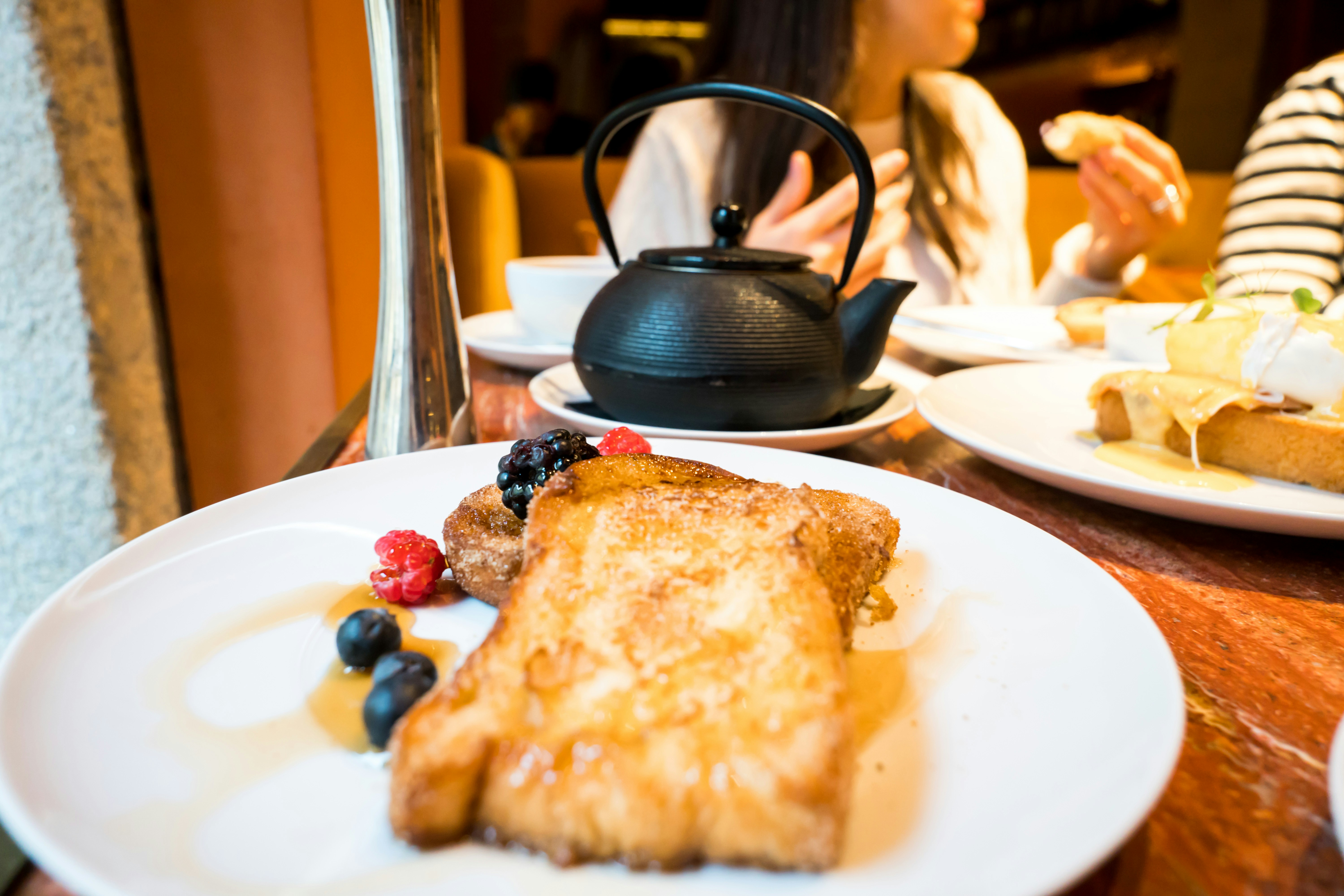 Golden French Toast with Berry Garnish in a Cozy Café Scene