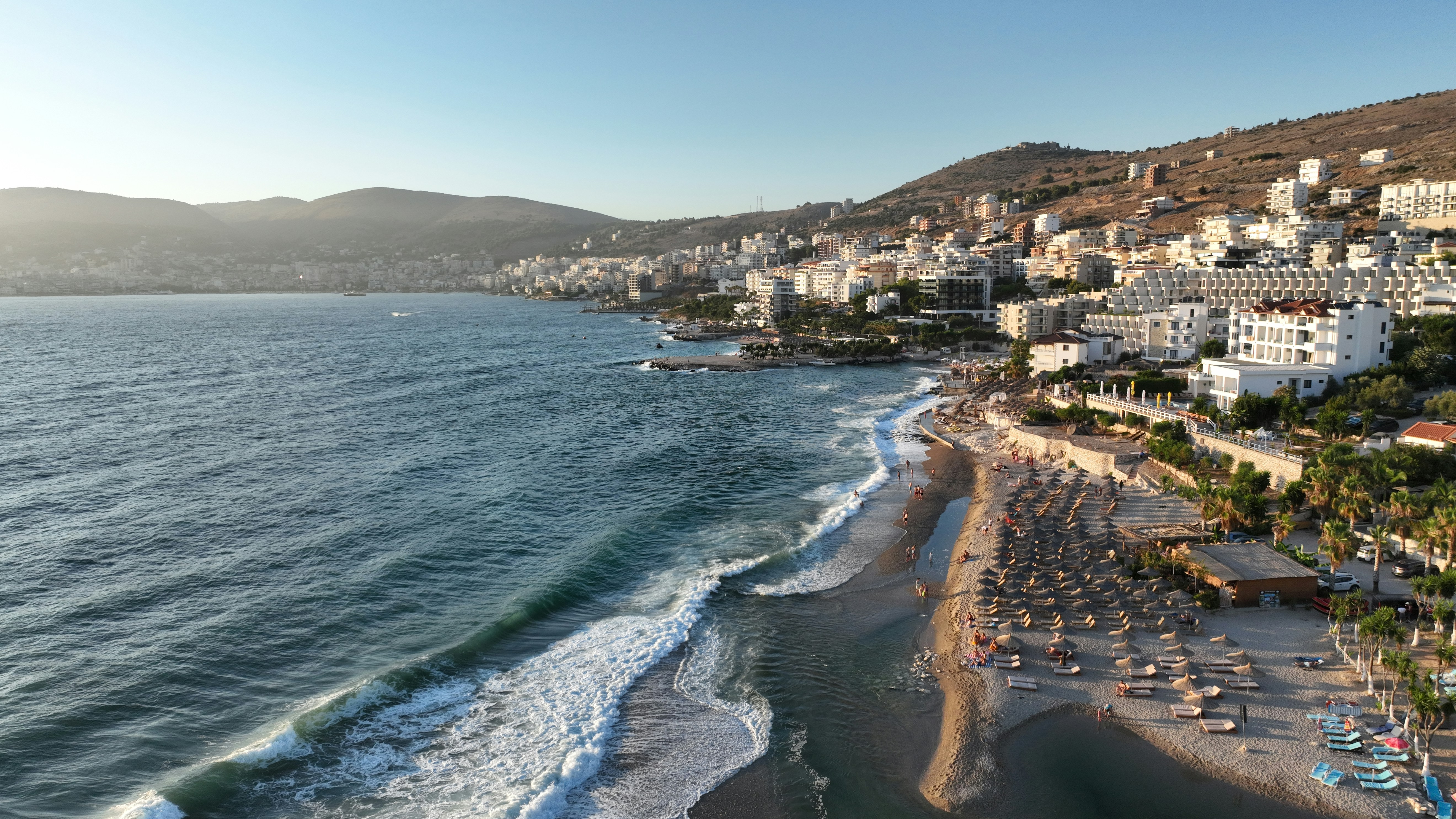 Coastal Urban Sunrise: Beachfront Confidence Beneath a Sloping Cityscape