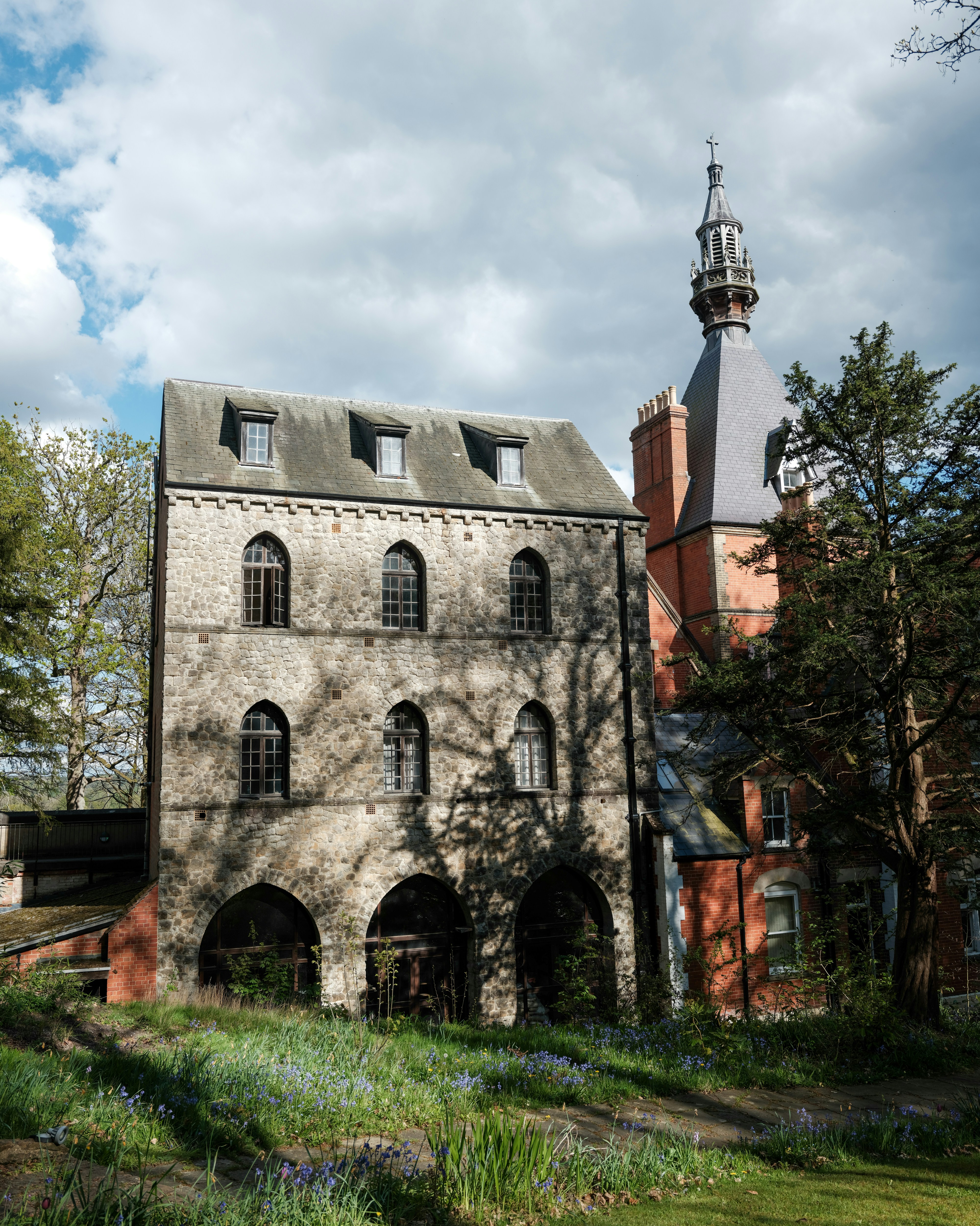 Stone House with Tower Overlooking a Violet-Flowered Garden