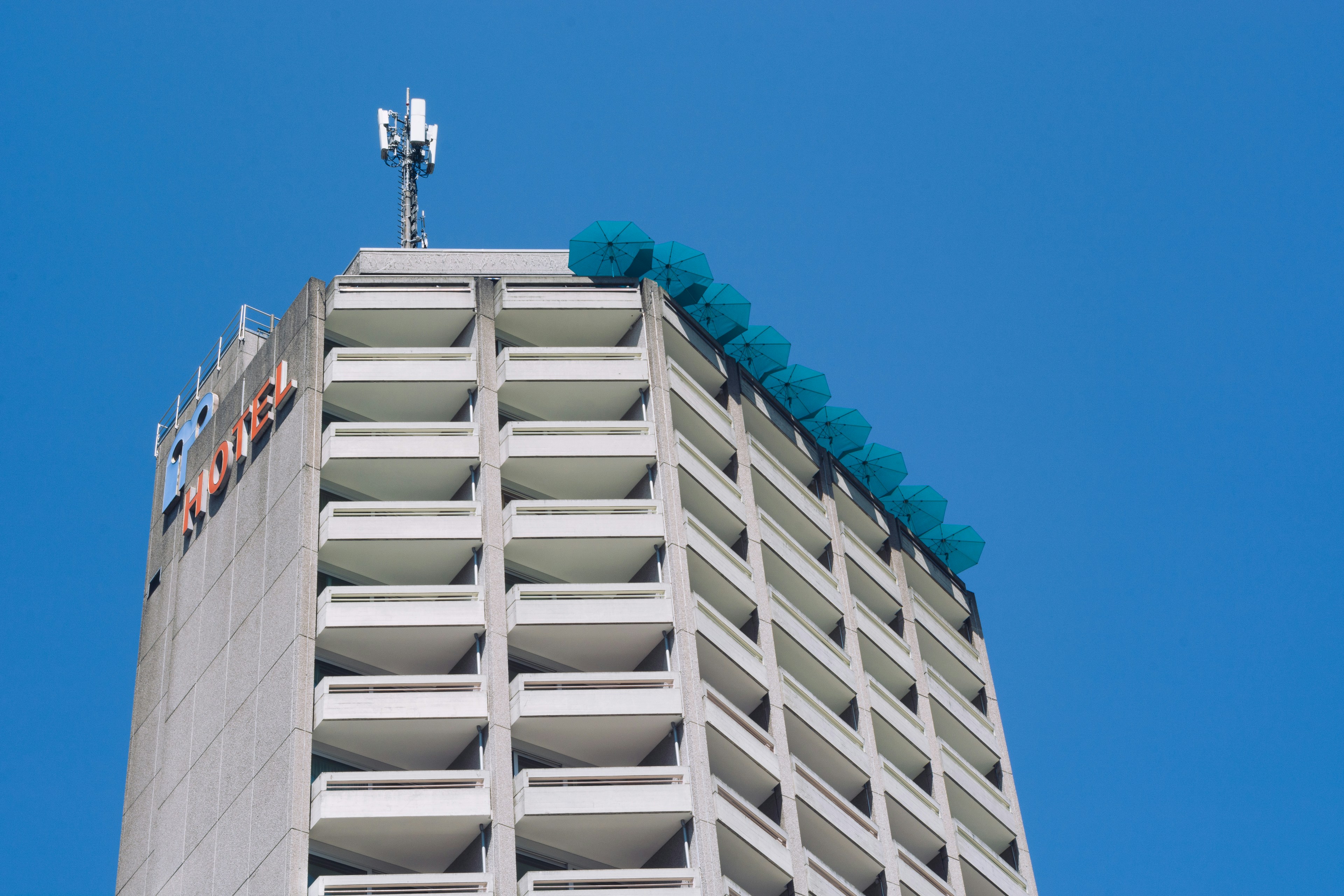 Rising Front: A Concrete Facade Reaches Toward a Clear Sky