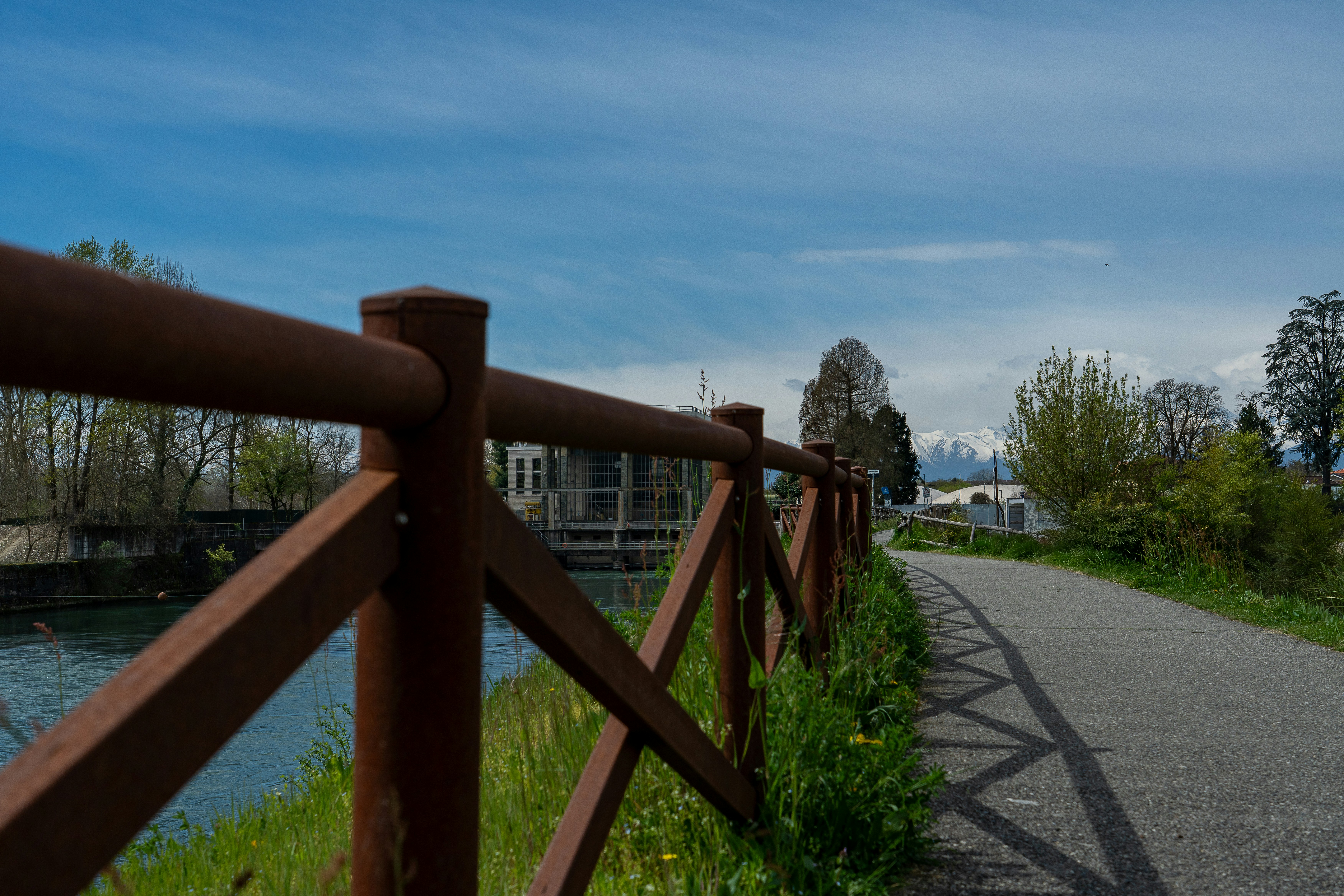 Riverside Promenade: Wooden Railings and Sunlit Path