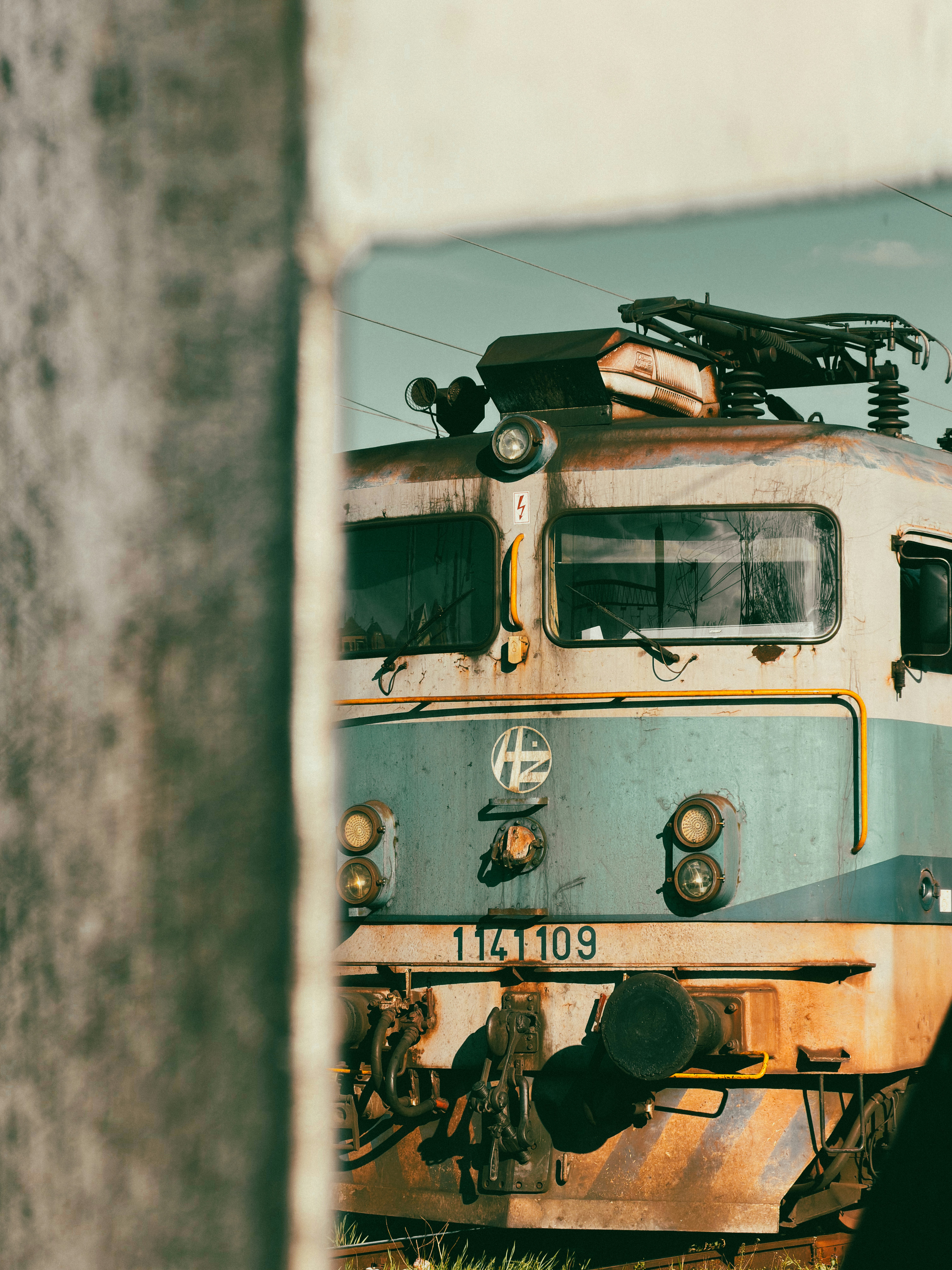 Rust and Rails: The Weathered Locomotive Peeking from a Concrete Gap