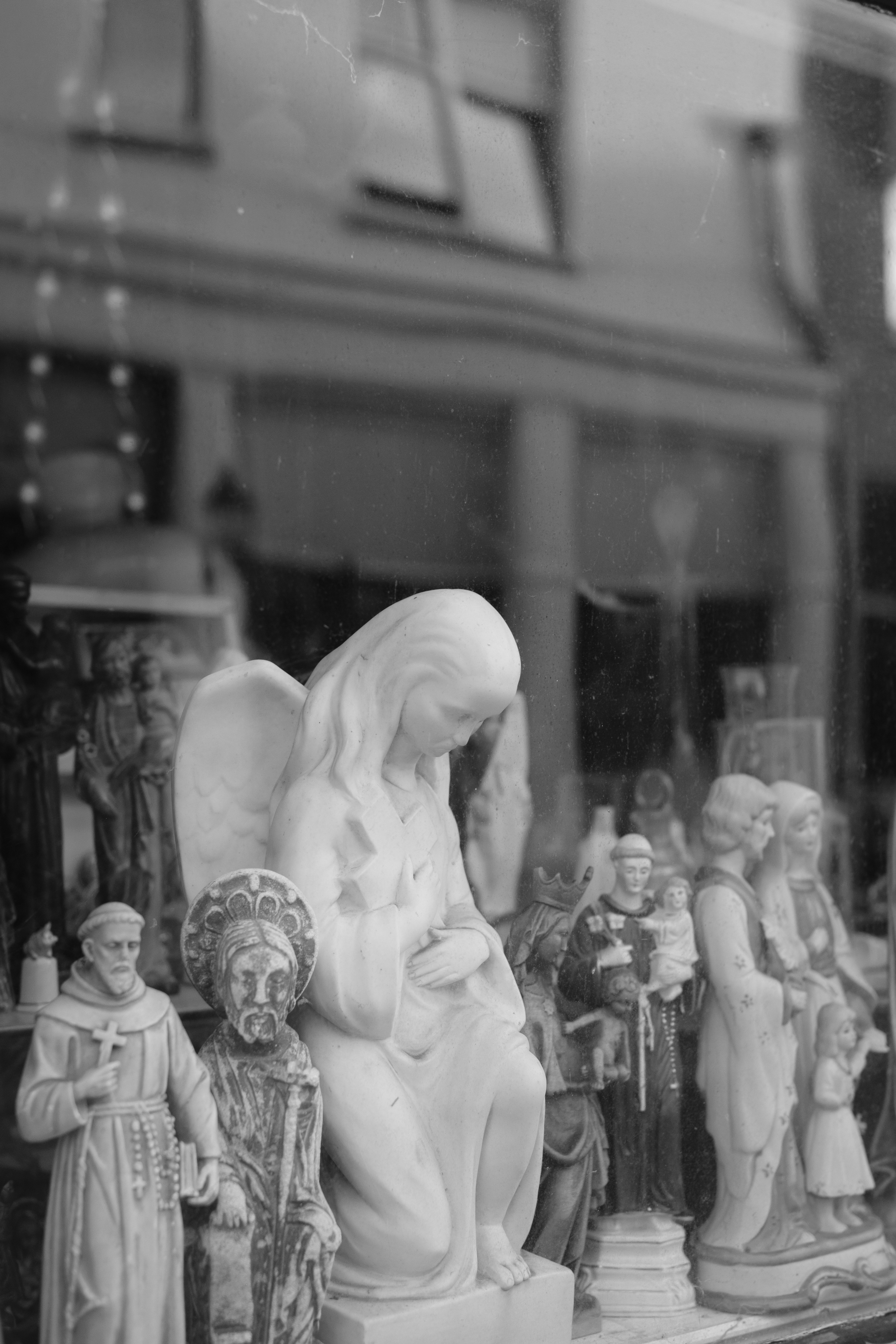Calm Angel among Carved Saints in a Street Window