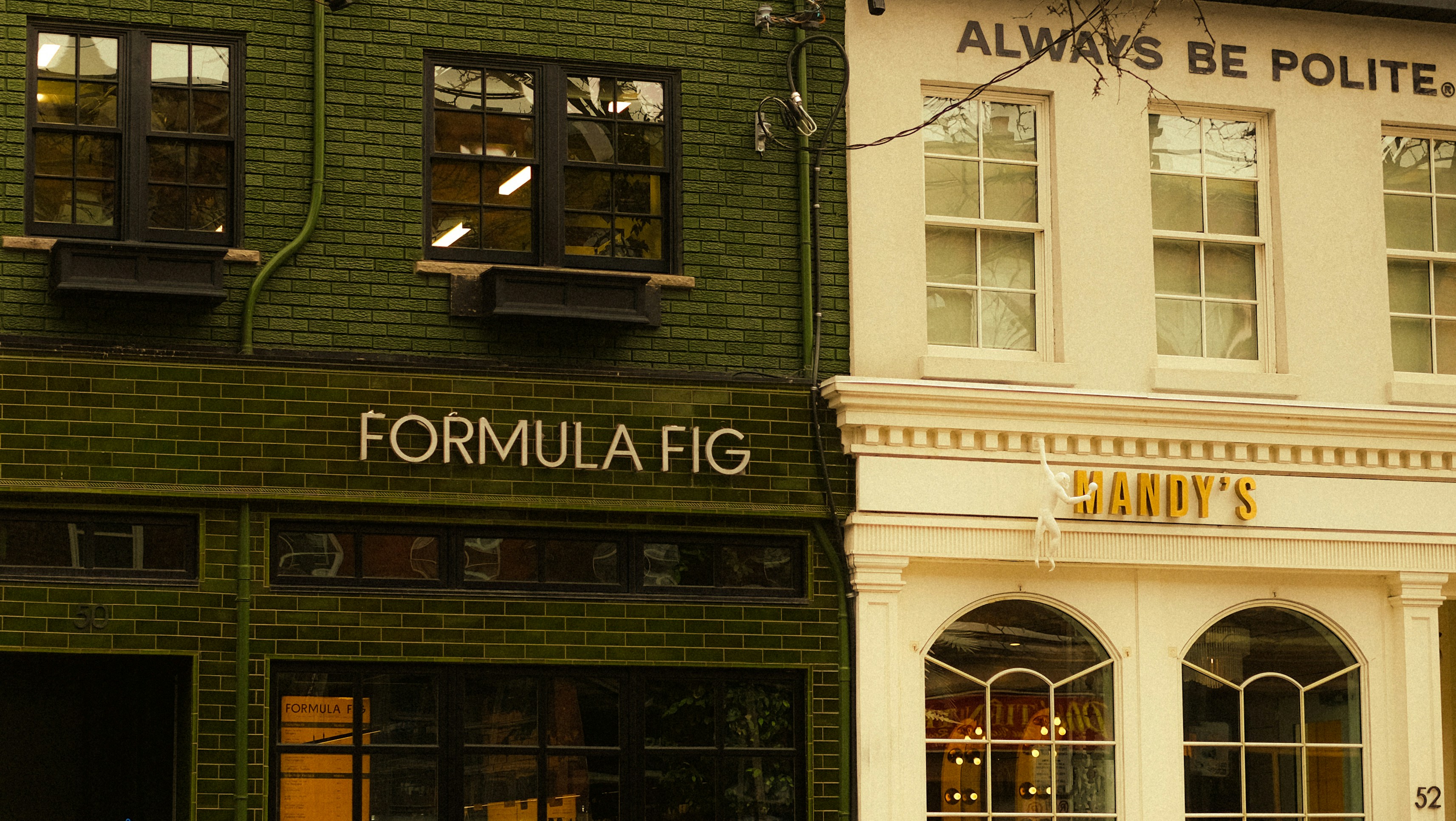 Formulaic storefronts: a green brick shop next to a cream-colored facade