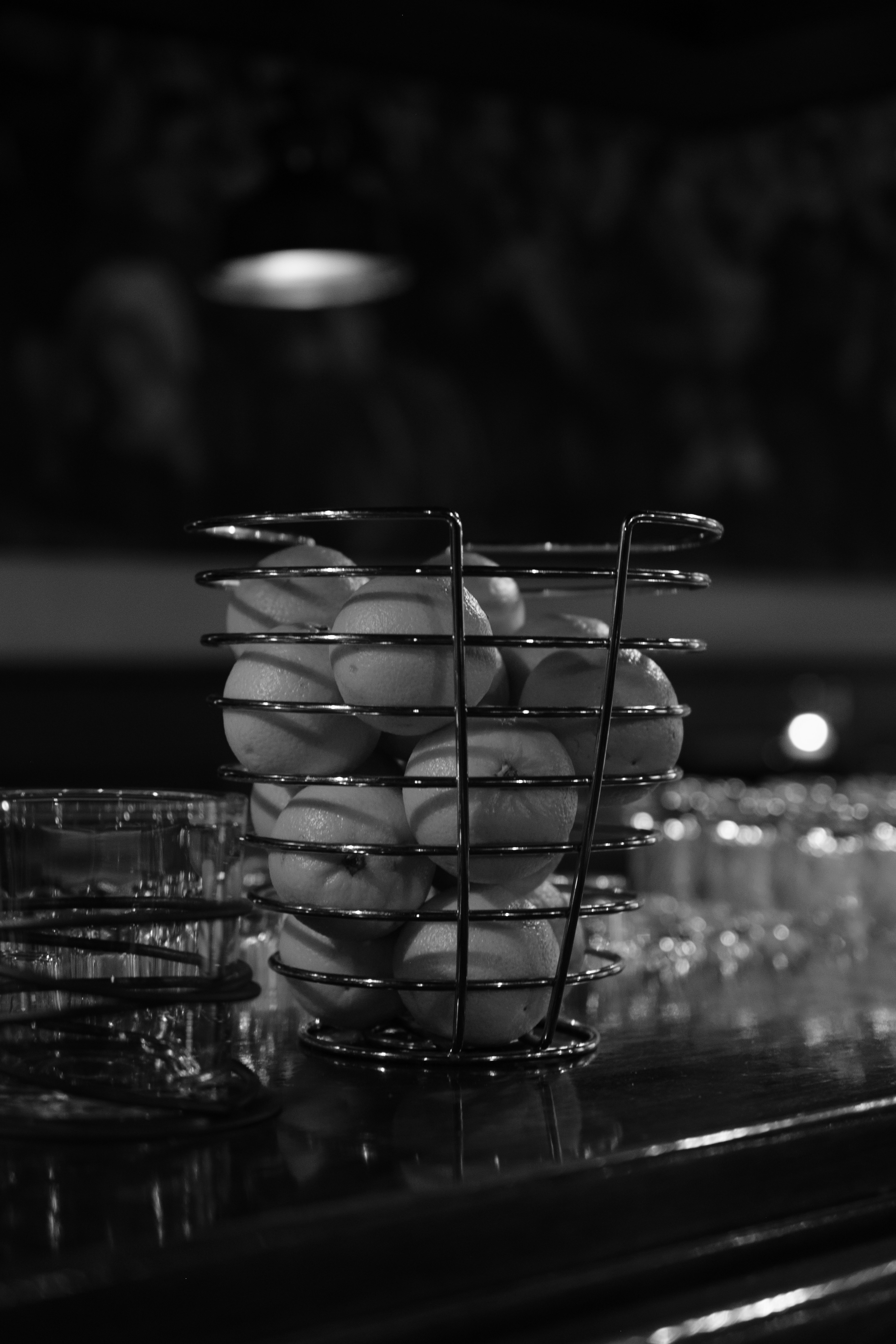 Stack of Peaches in a Cozy Wire Basket on a Reflective Bar Surface