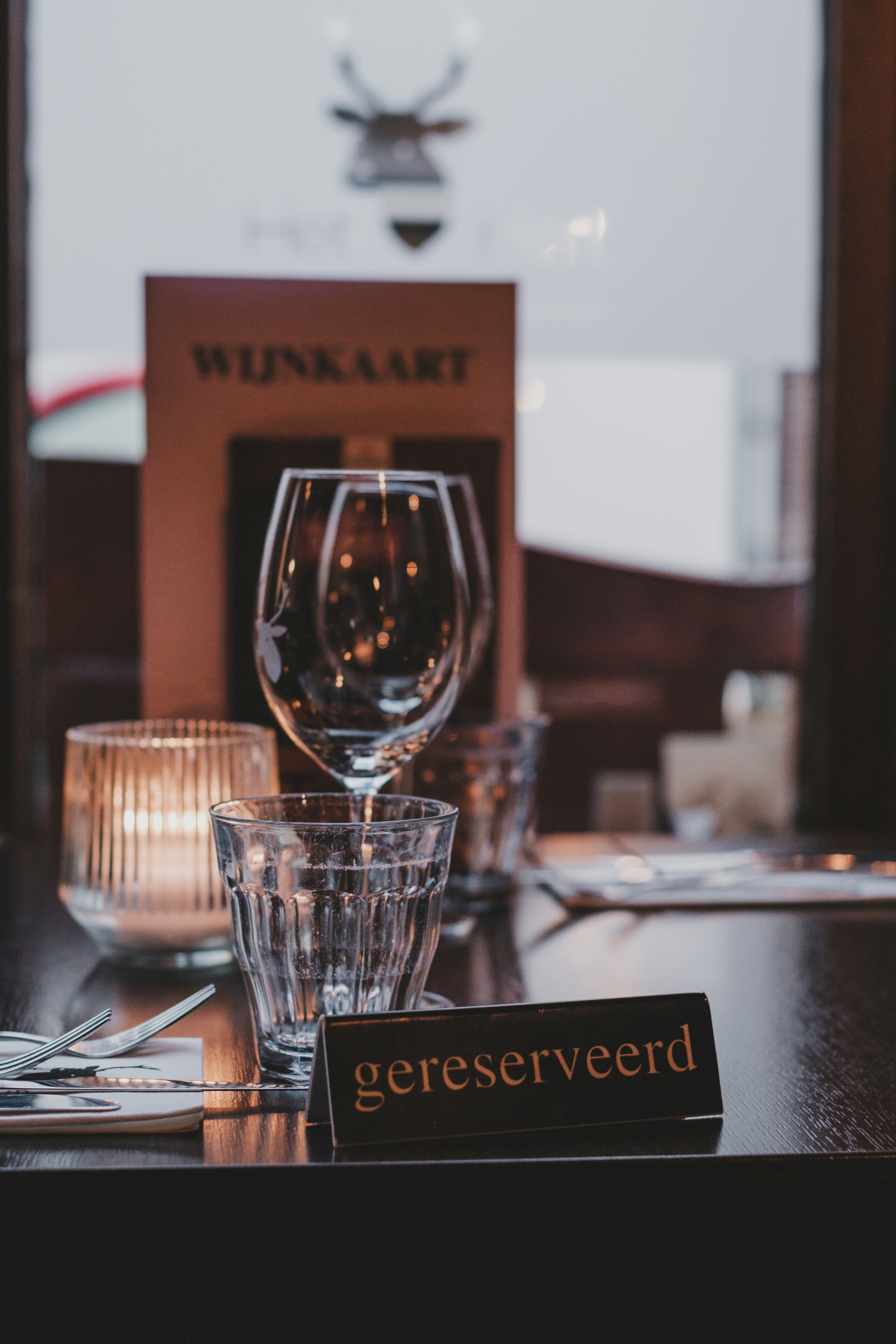 Amber Dinner: a softly lit table with a reserved card and glassware
