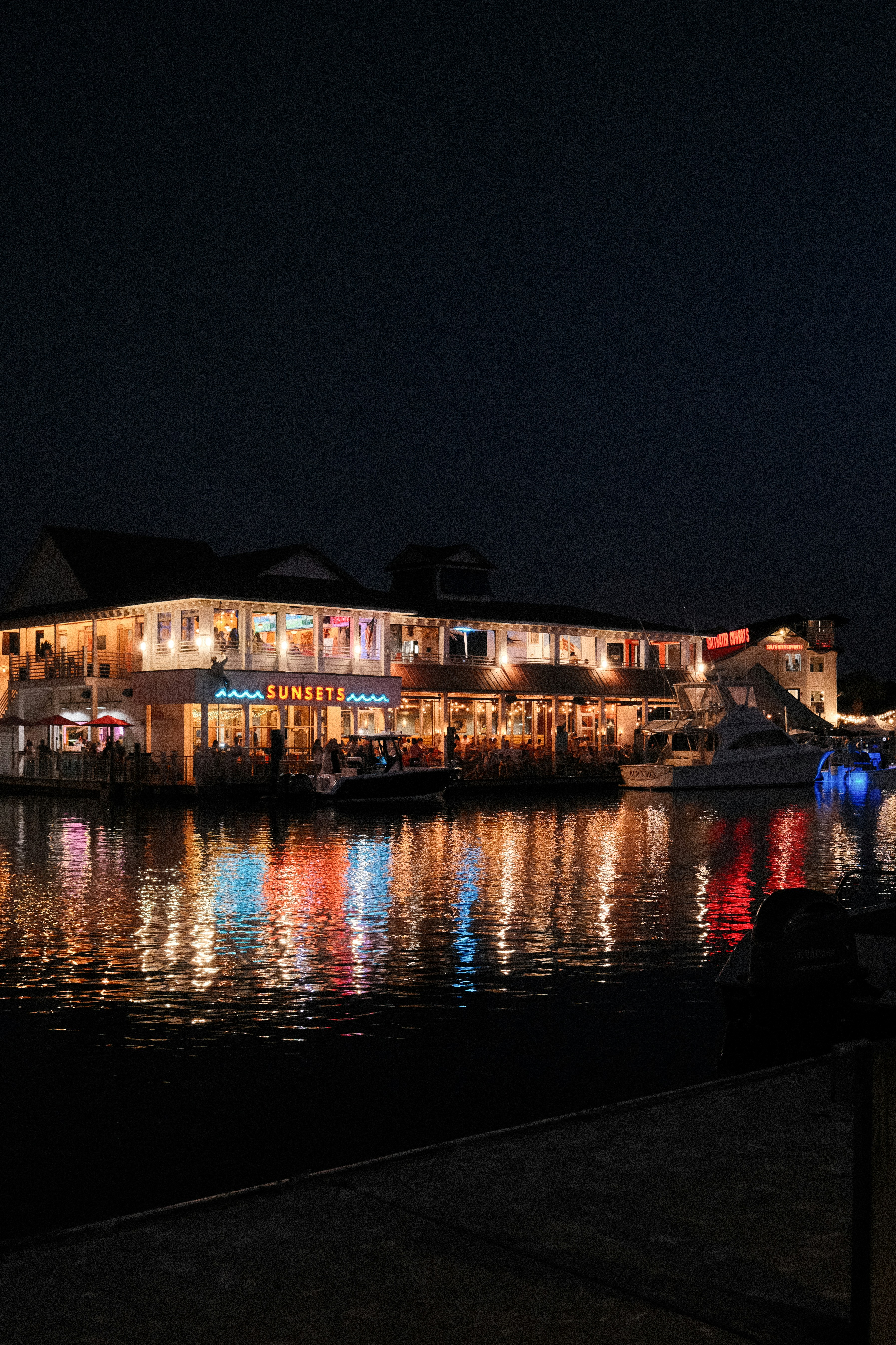 Neon Harbor at Night: Sunset Saloon by the Water
