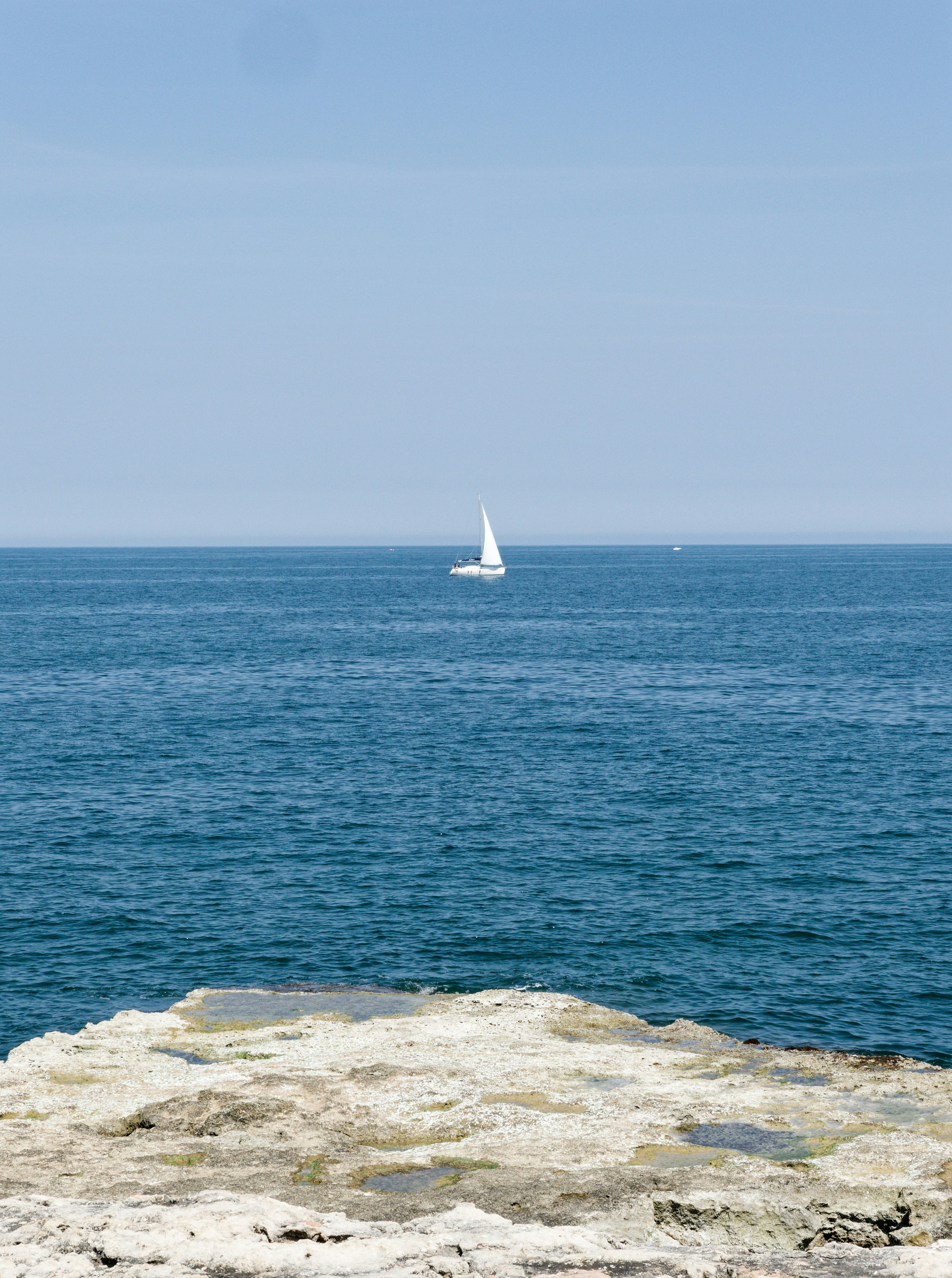 White Sail Against the Quiet Horizon