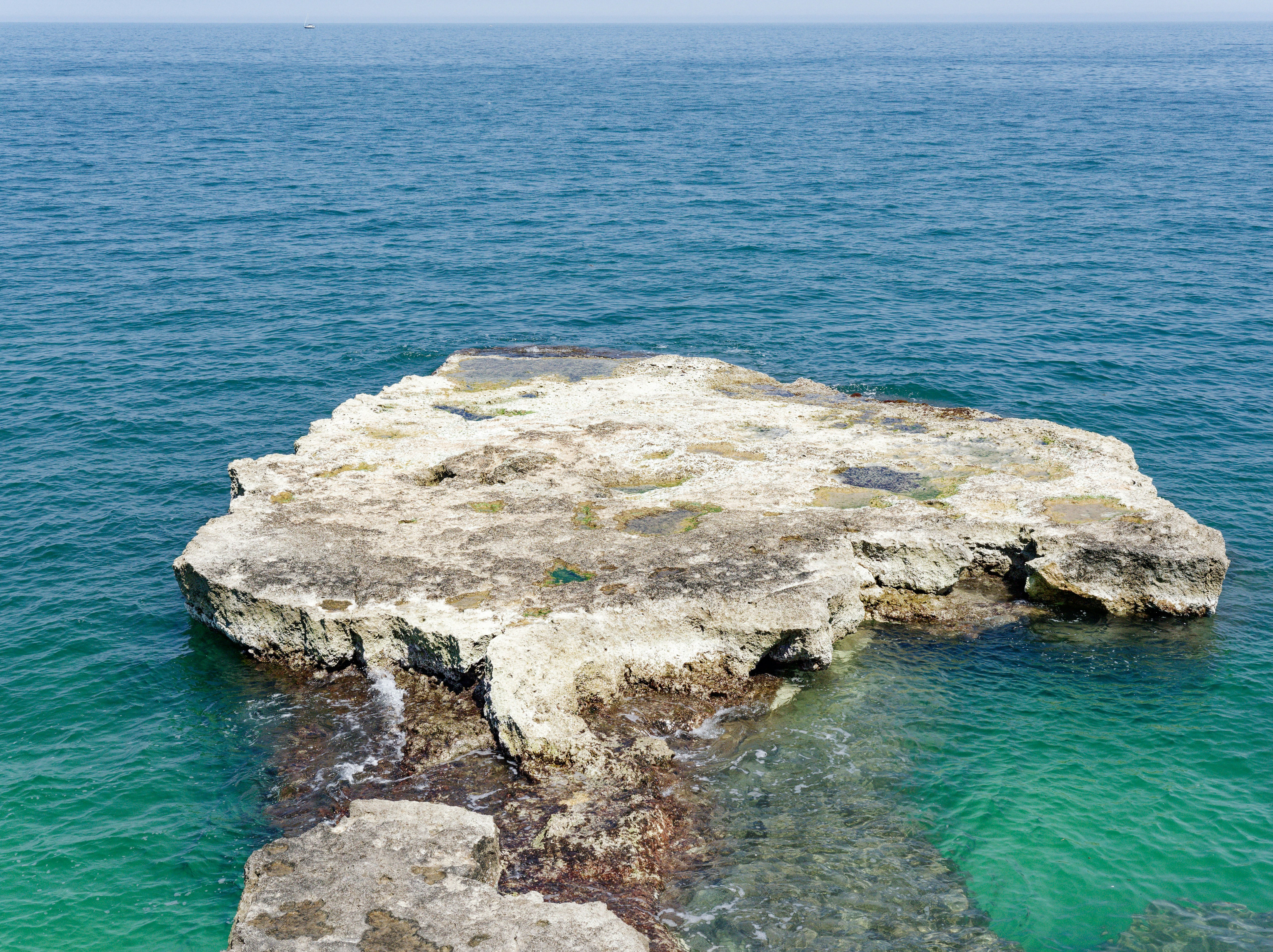 Isolated sea platform jutting into turquoise light