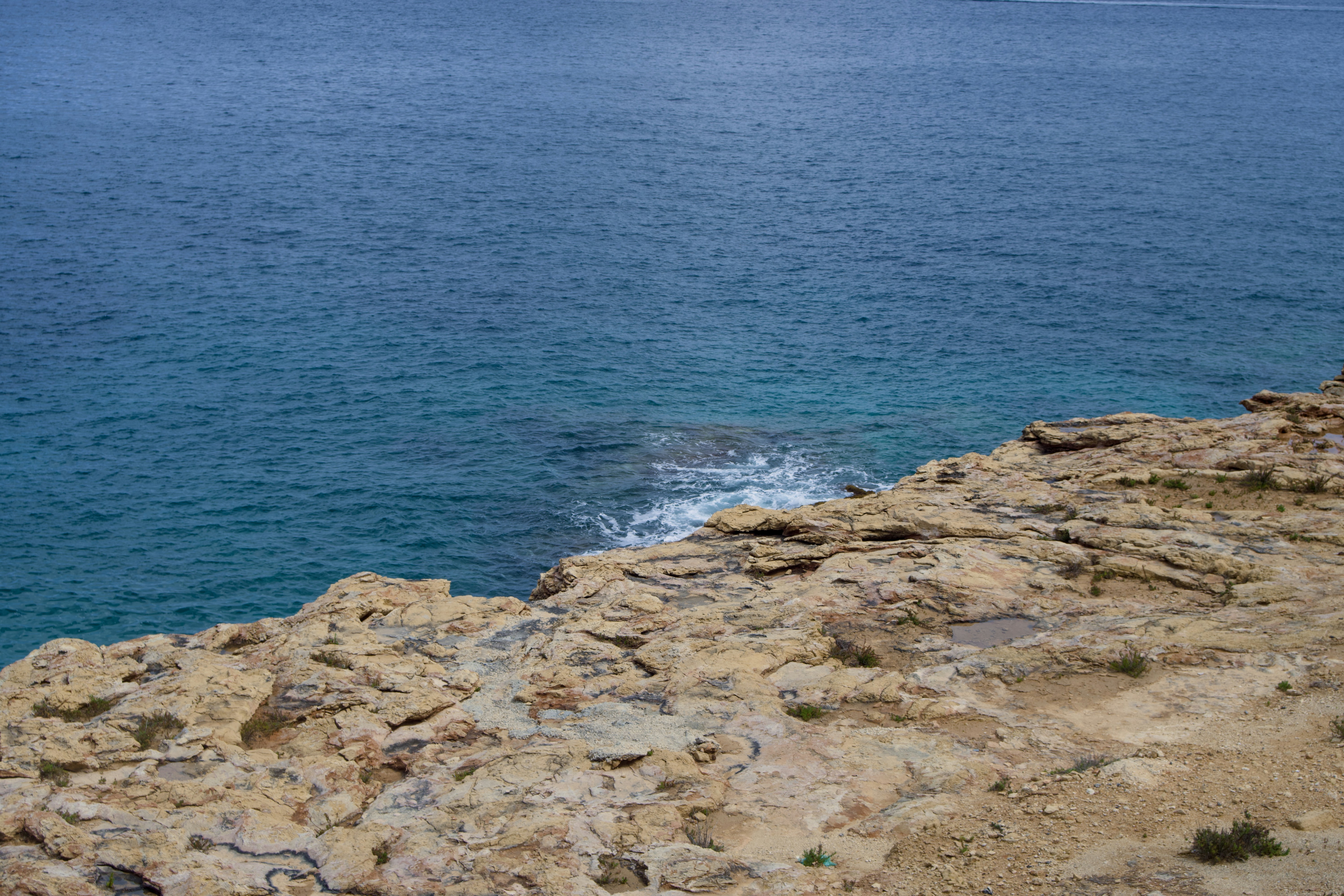 Rugged shoreline meeting a calm turquoise sea