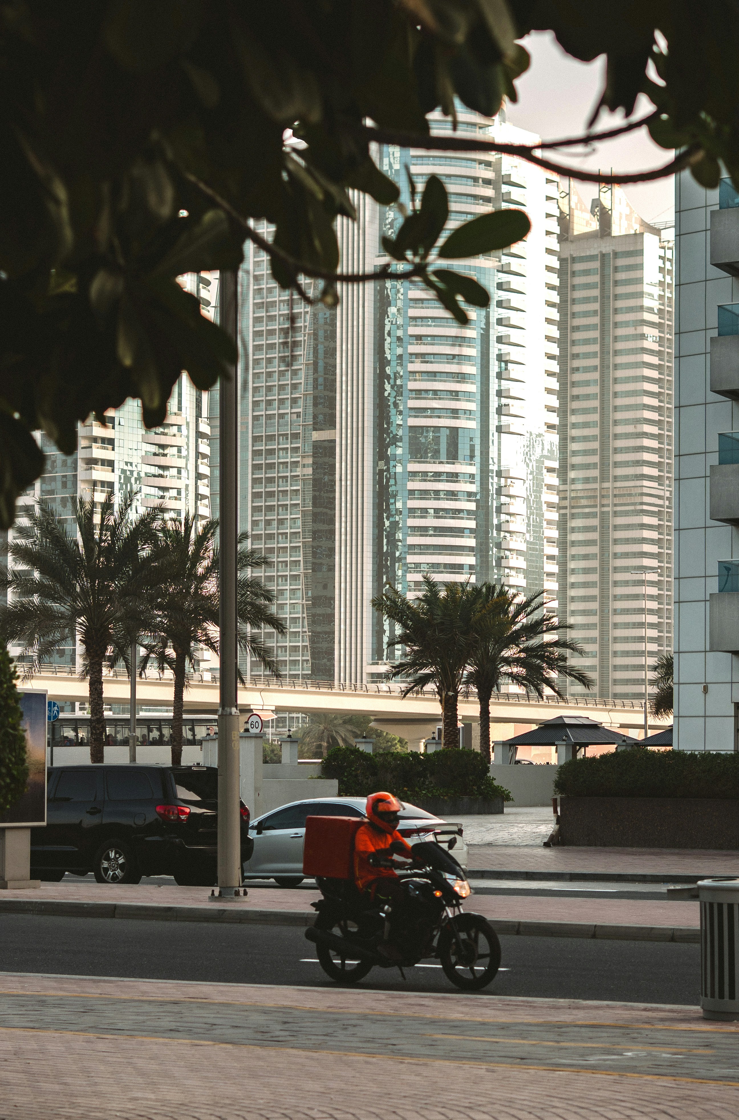 Urban courier in motion beneath a canyon of glass towers