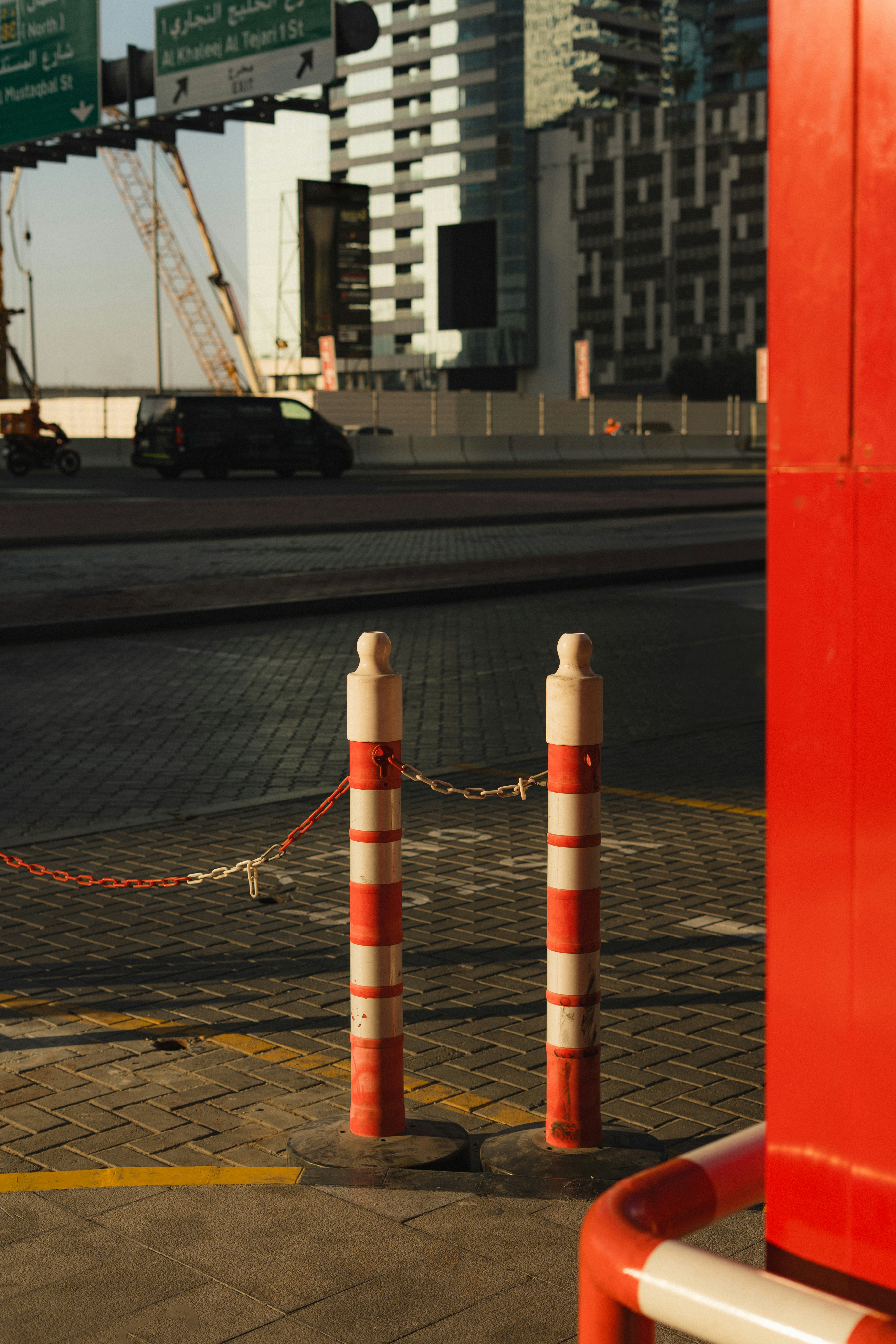 Urban Barrier: Red-and-White Poles Guard a Quiet Street