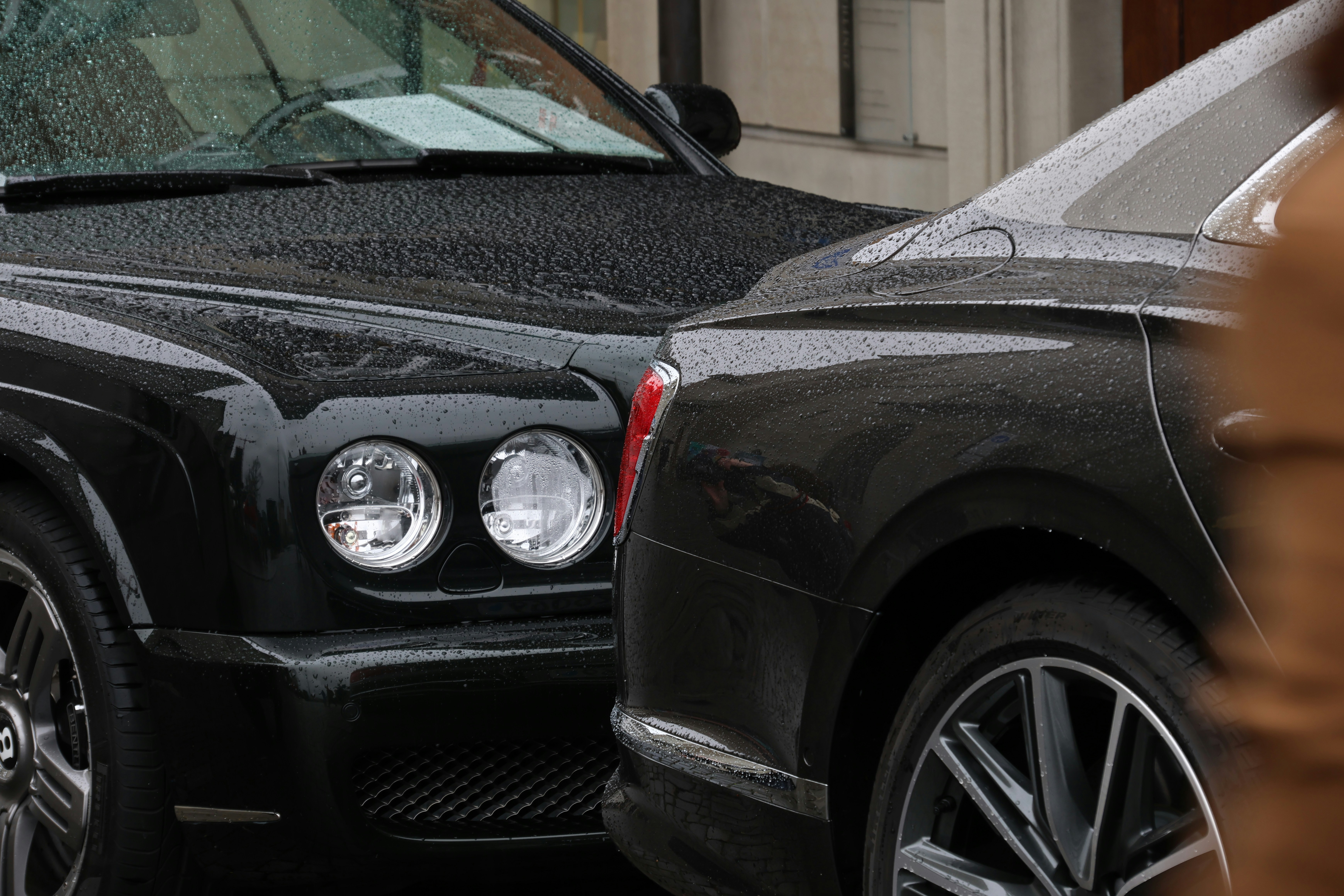 Close Pass: The Front Edges of Luxury Meet in Rain-Damp Street