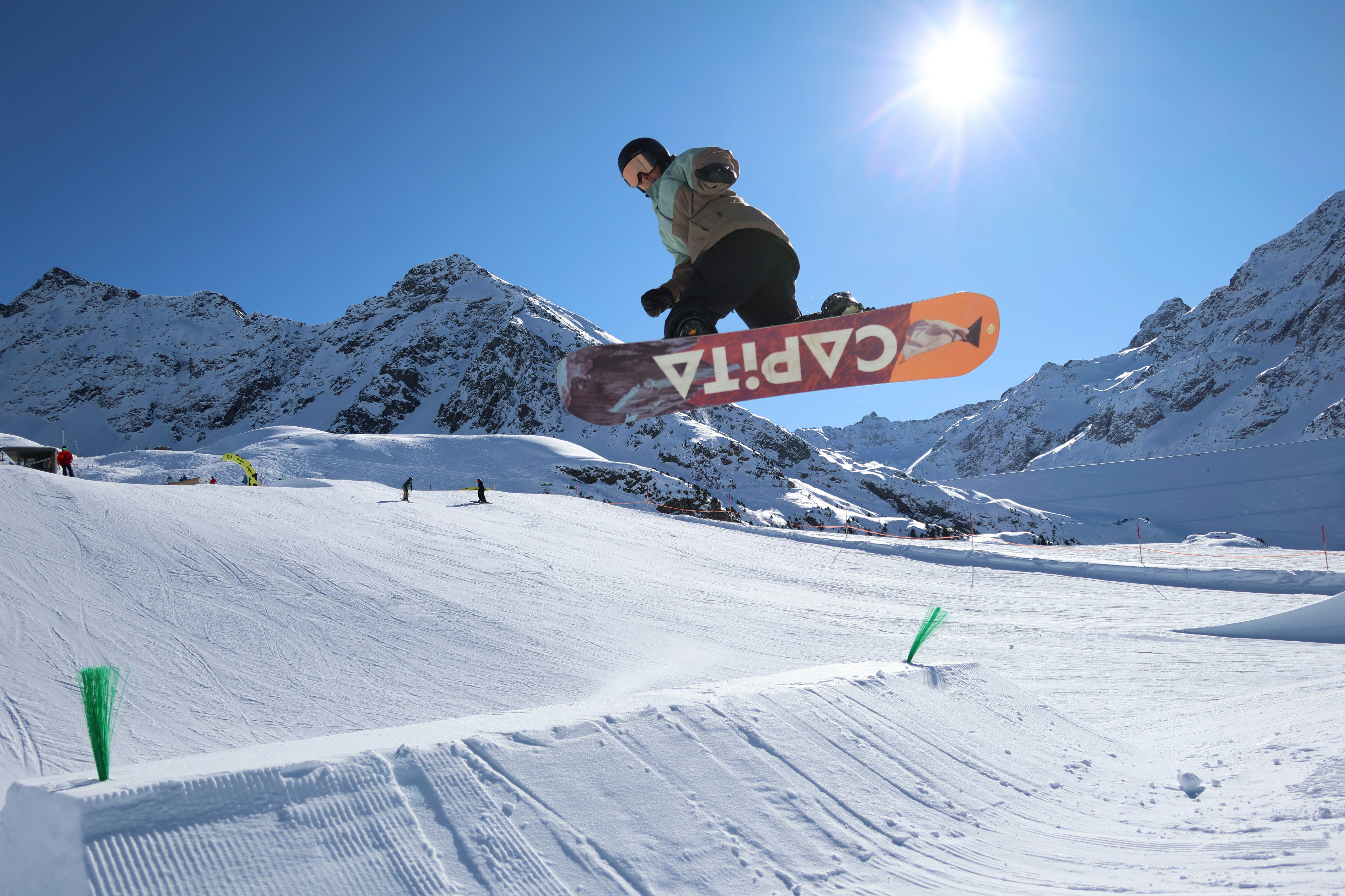 Aerial Snowboard Jump Over a Glacier Ridge under a Bright Alpine Sun