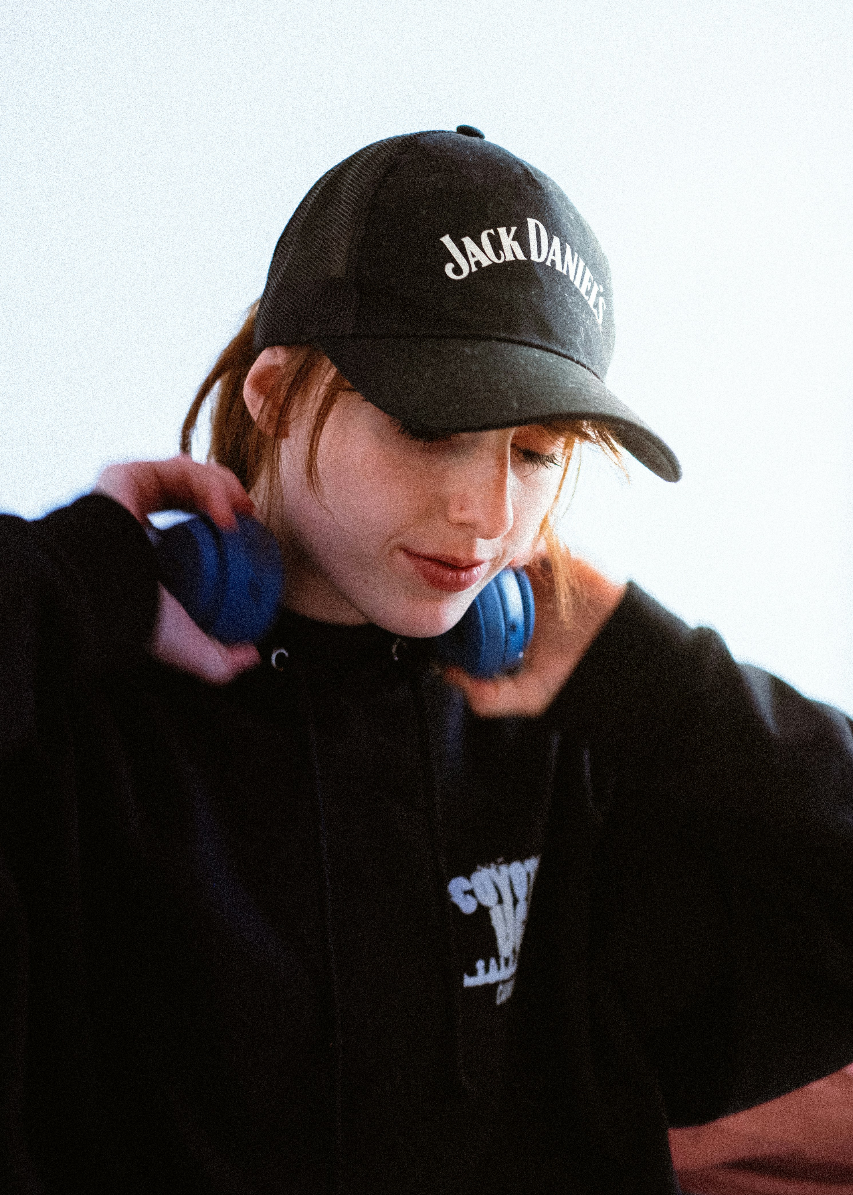 Cap and headphones: a cropped moment of quiet intensity
