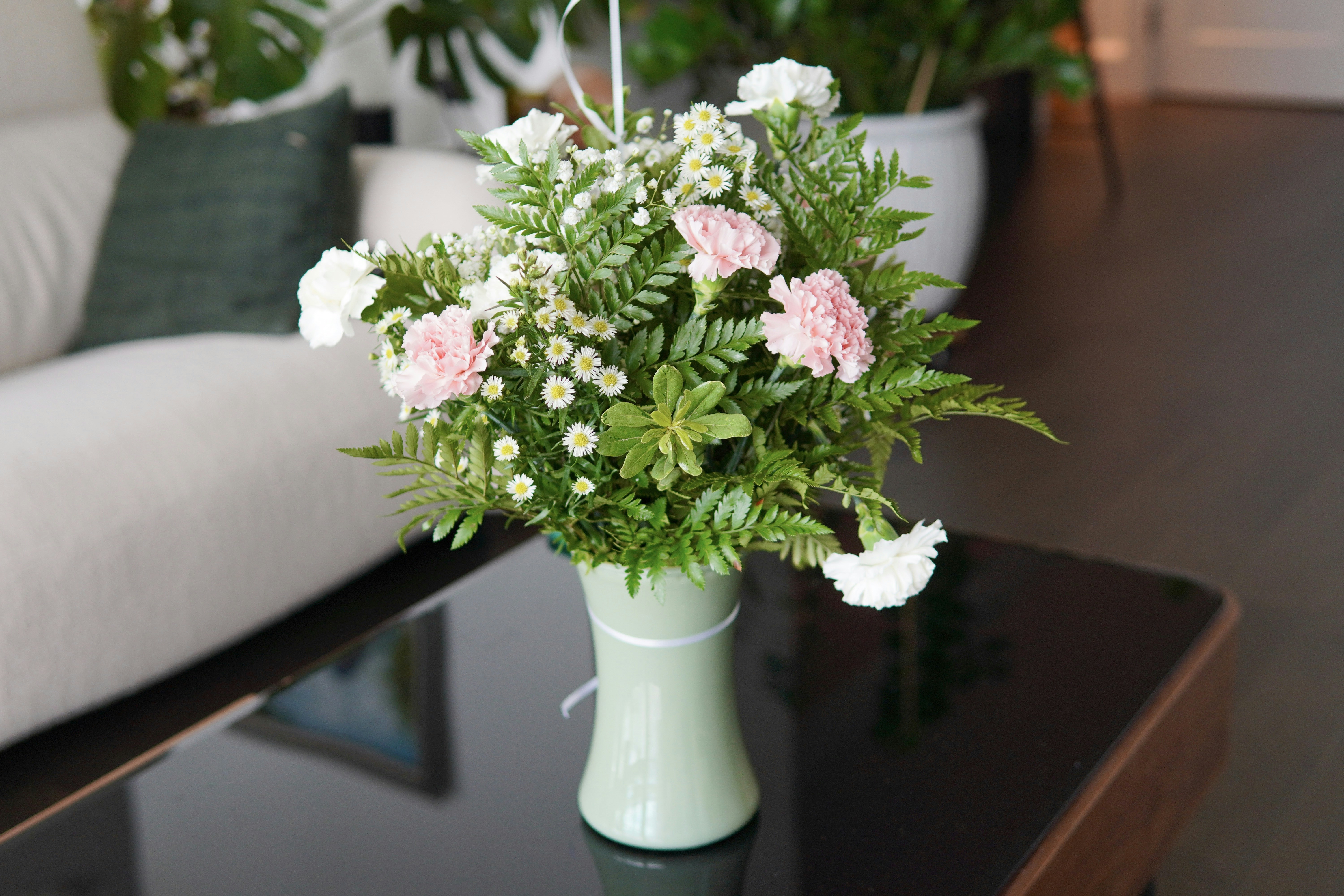 Vivid bouquet in ceramic vase graces a glossy coffee table