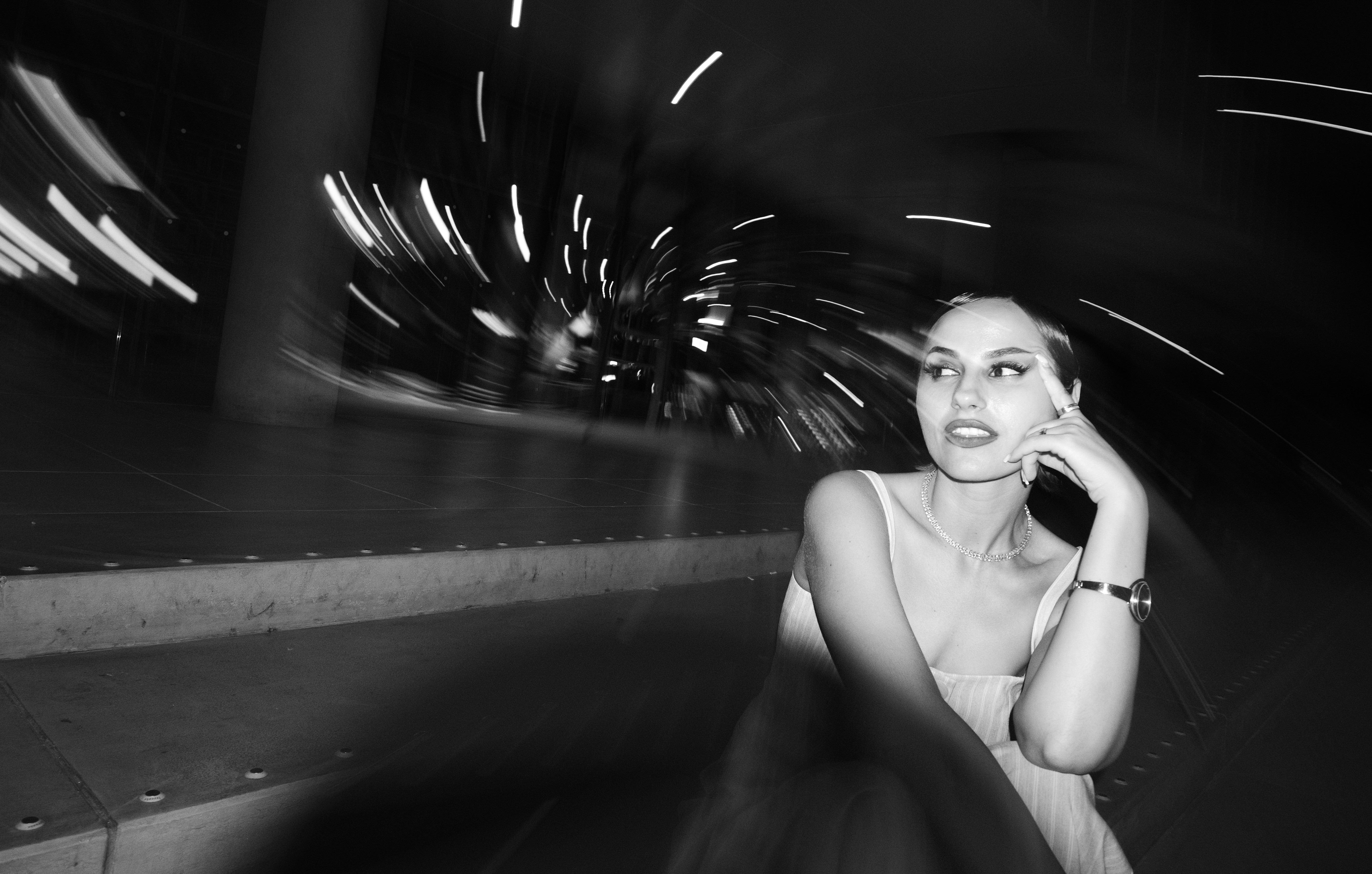 Nighttime Portrait in Motion: A Subtle Gaze Amid Light Trails