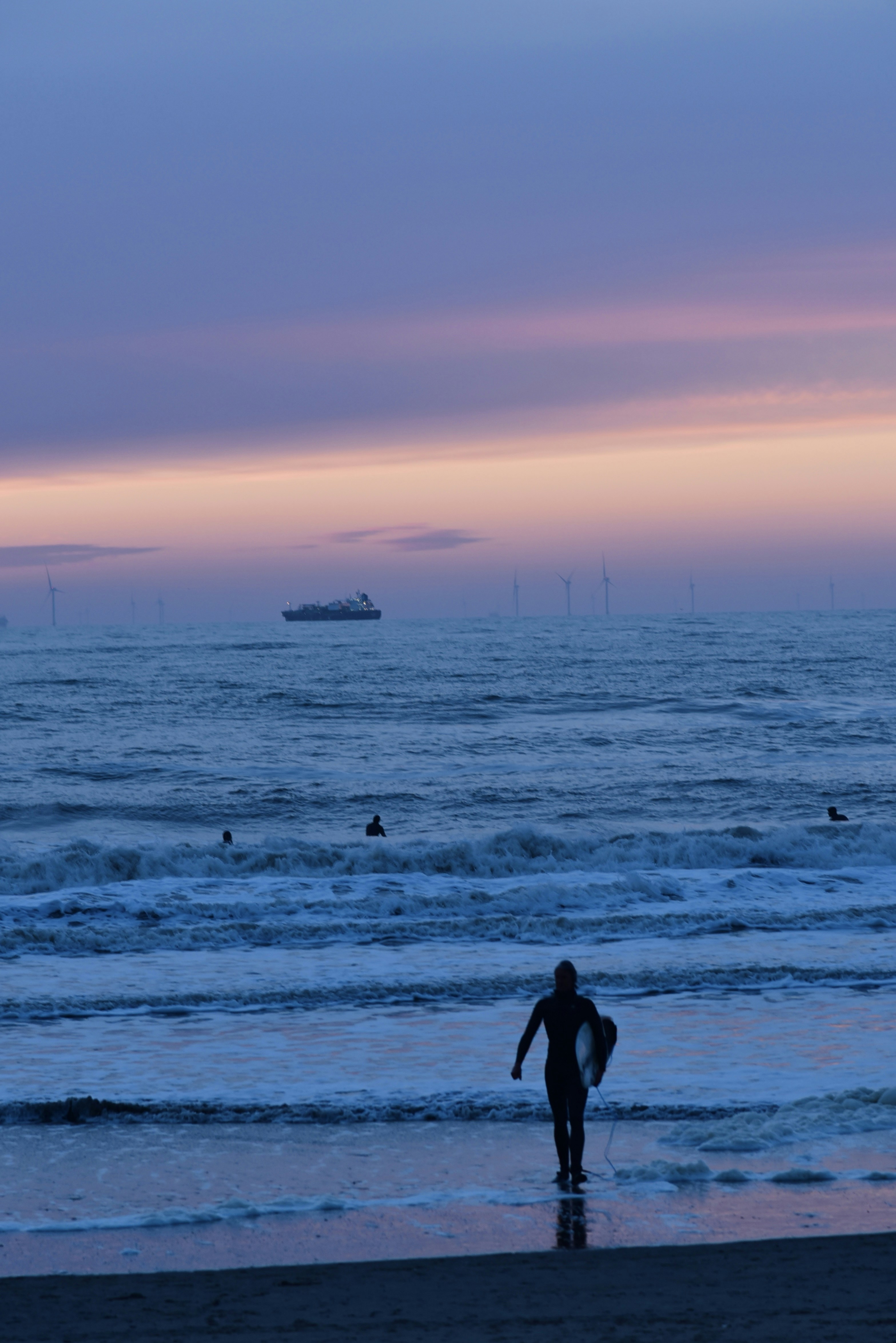 Silhouette at the Edge: Surfer's Last Light Walk on a Velvet Sea