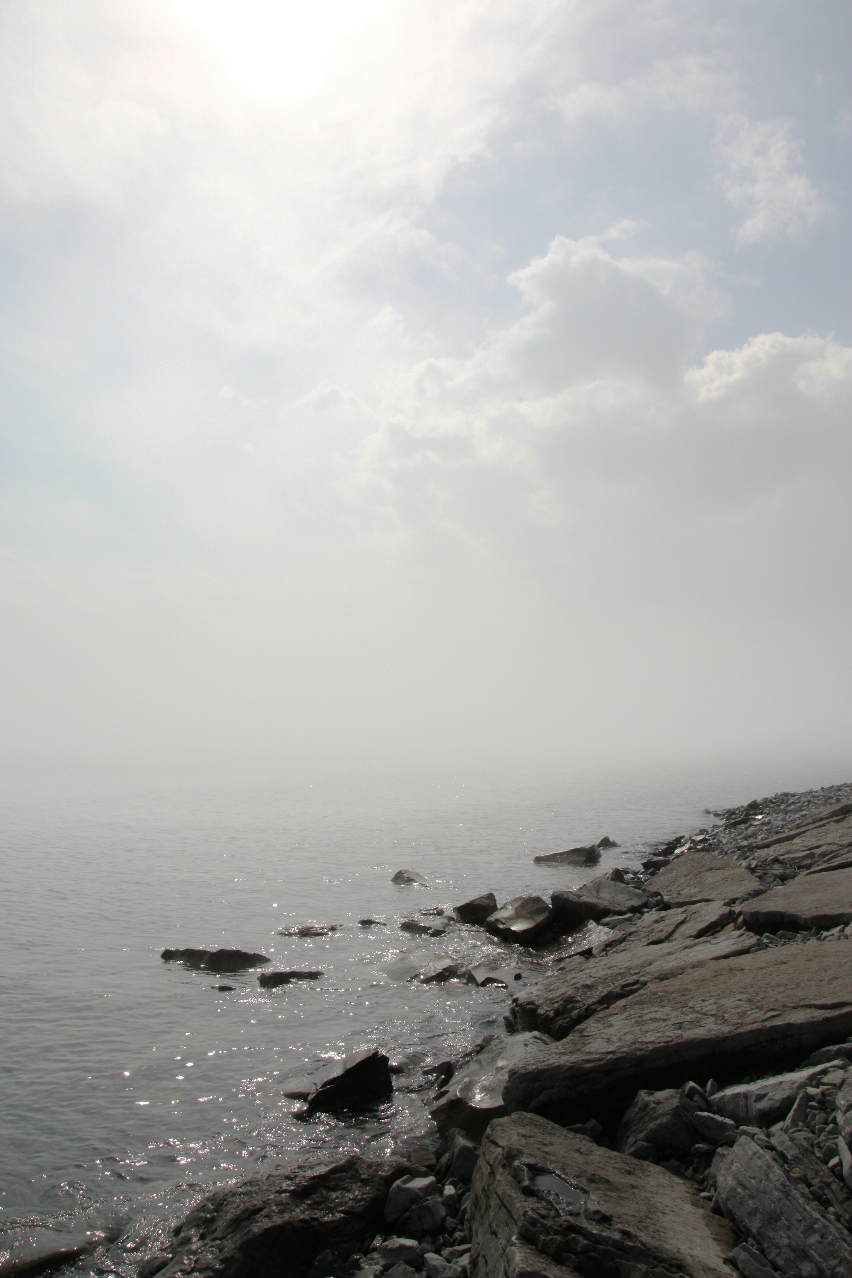 Shoreline Hushed by Mist: Rock and Sea at Dawn
