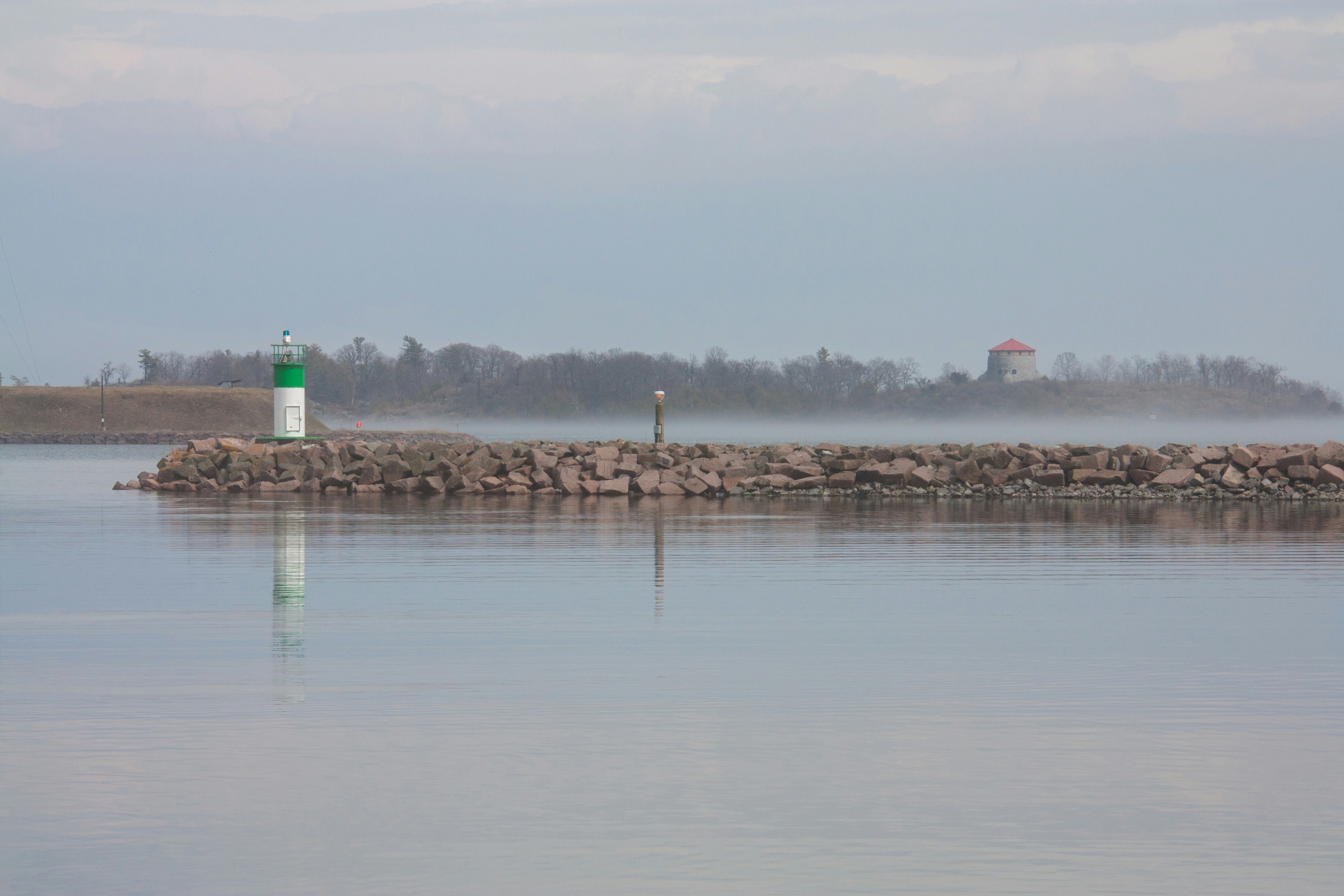 Lighthouse Sentinel: A Calm Barrier on a Misty Lake