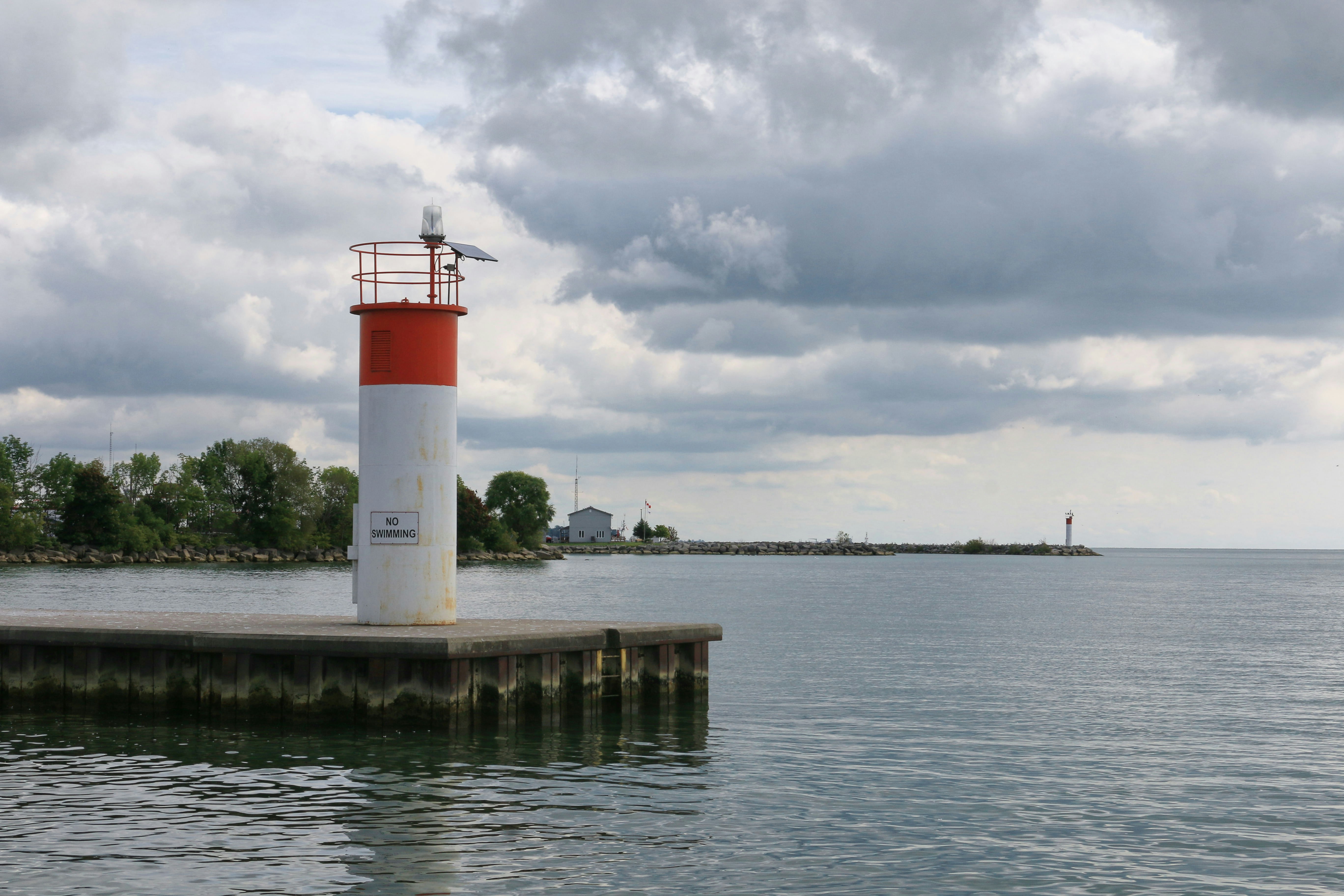 Beacon on the Pier: Red and White Tower Over Quiet Waters
