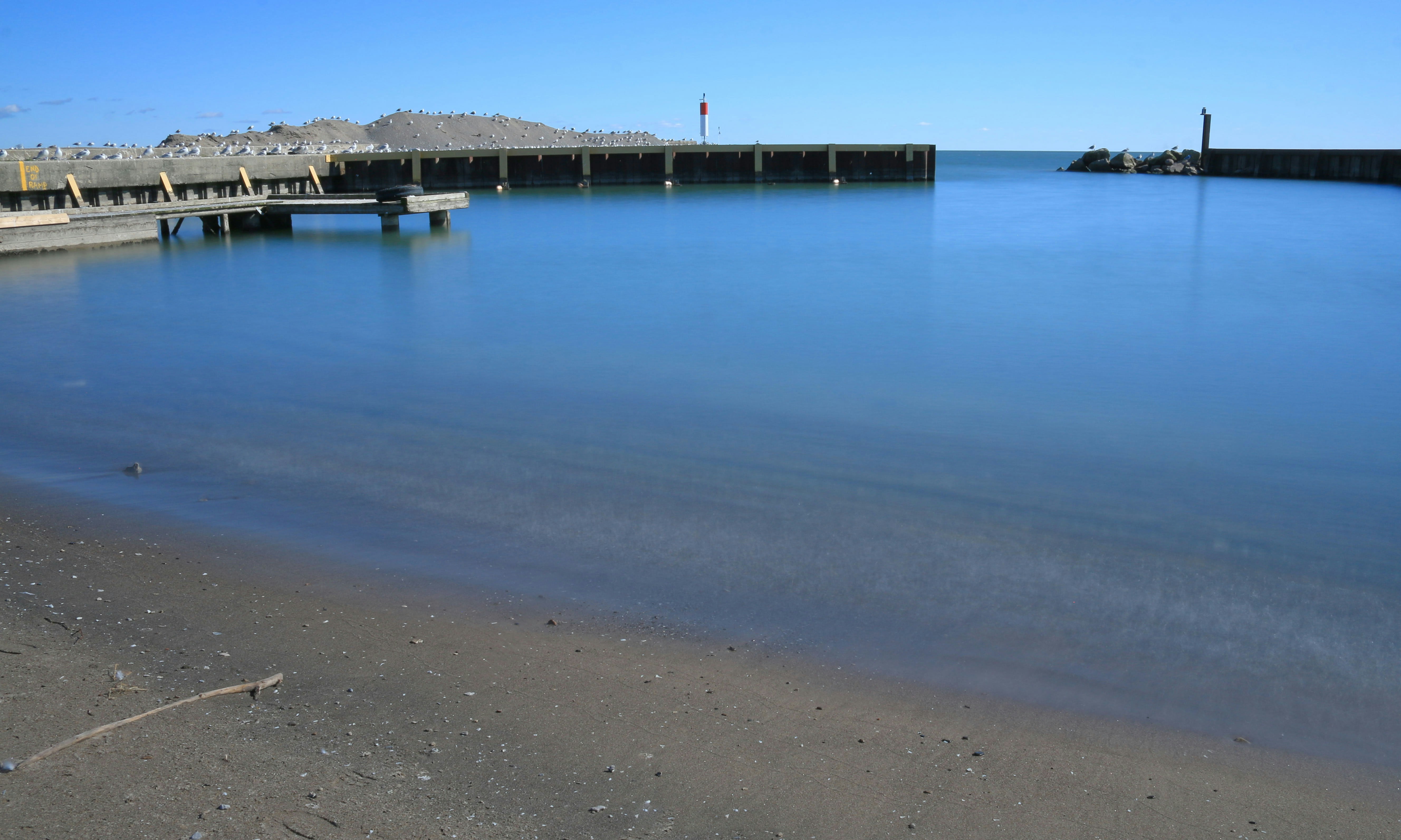 Quiet Harbor Horizon: A Calm Beach Reaches Toward a Pier