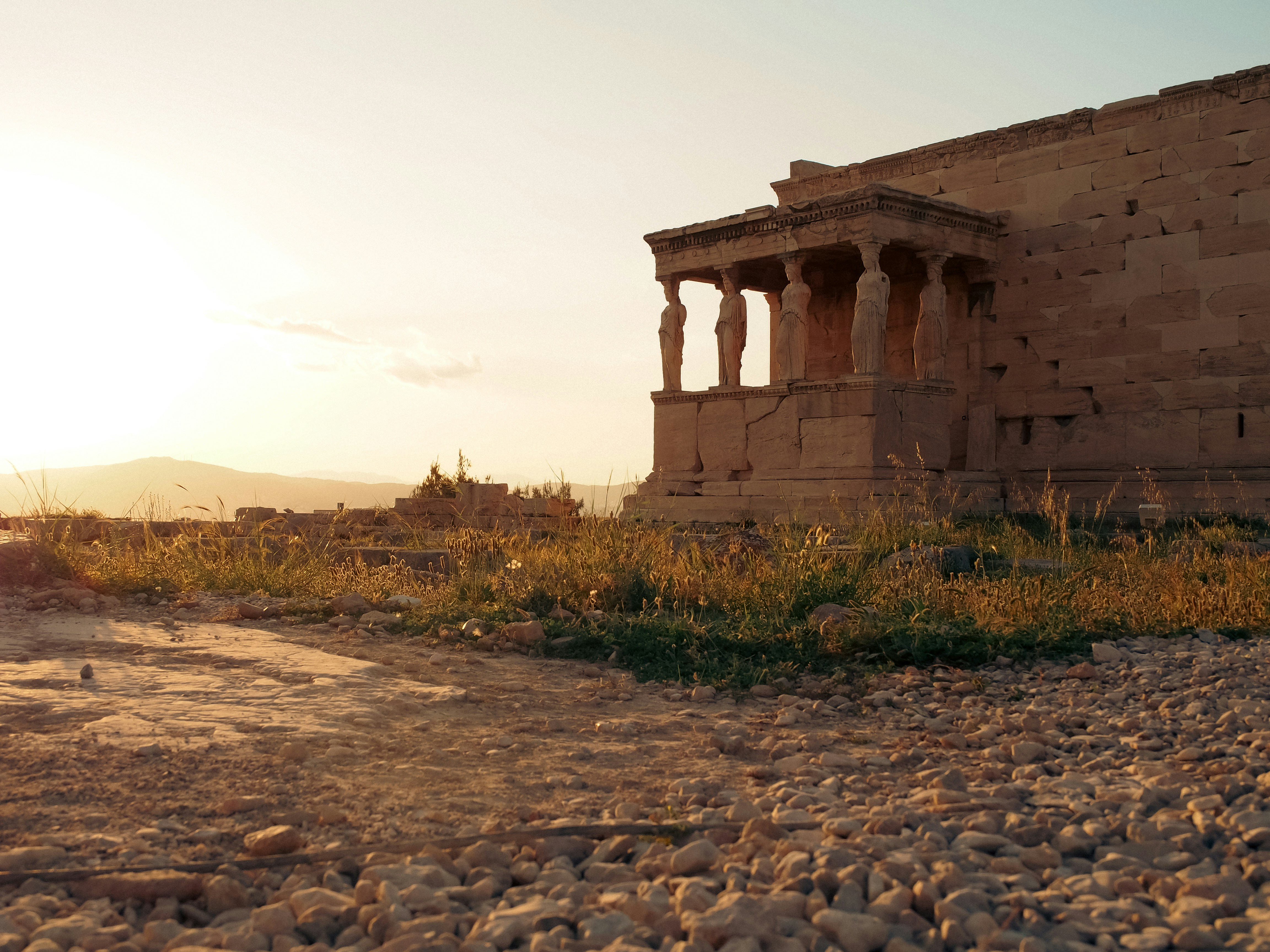 Sunlit Ruins: An Eroded Temple at Dusk Over Pebbled Ground