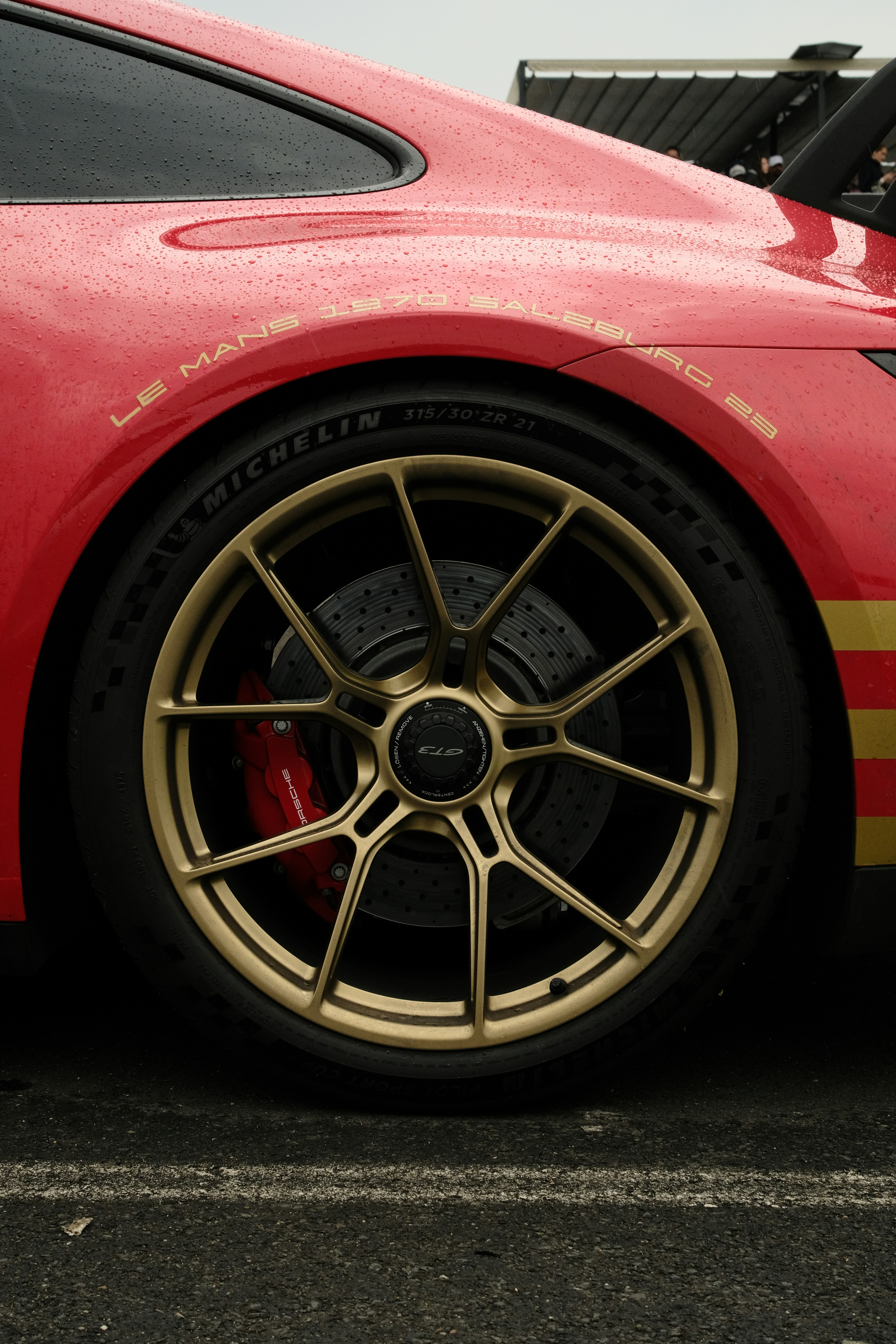Golden spokes and red brake glow: a close-up of a high-performance Porsche wheel