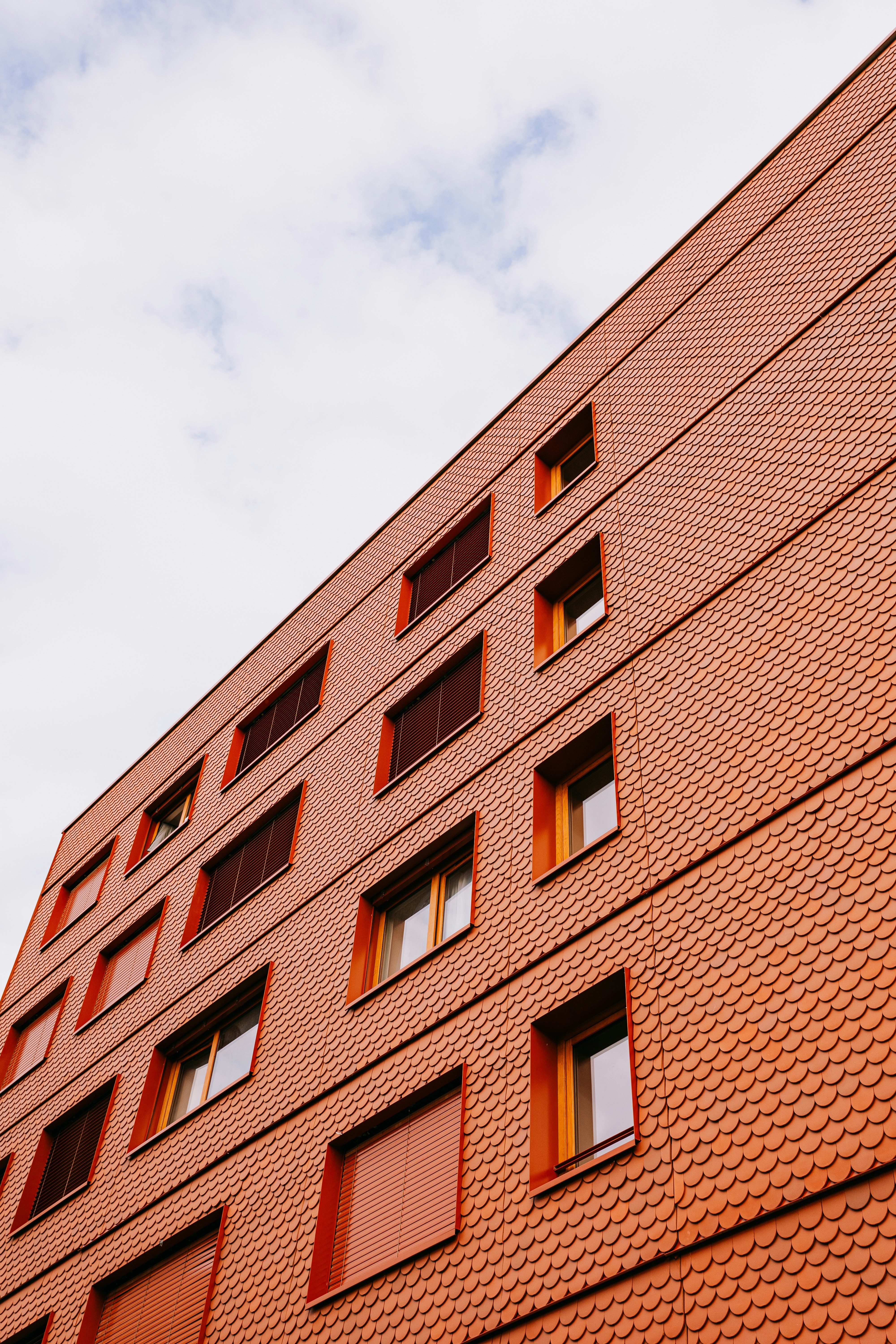 Brick Facade in Perspective: Windows Like Stitches on a Slanted Wall