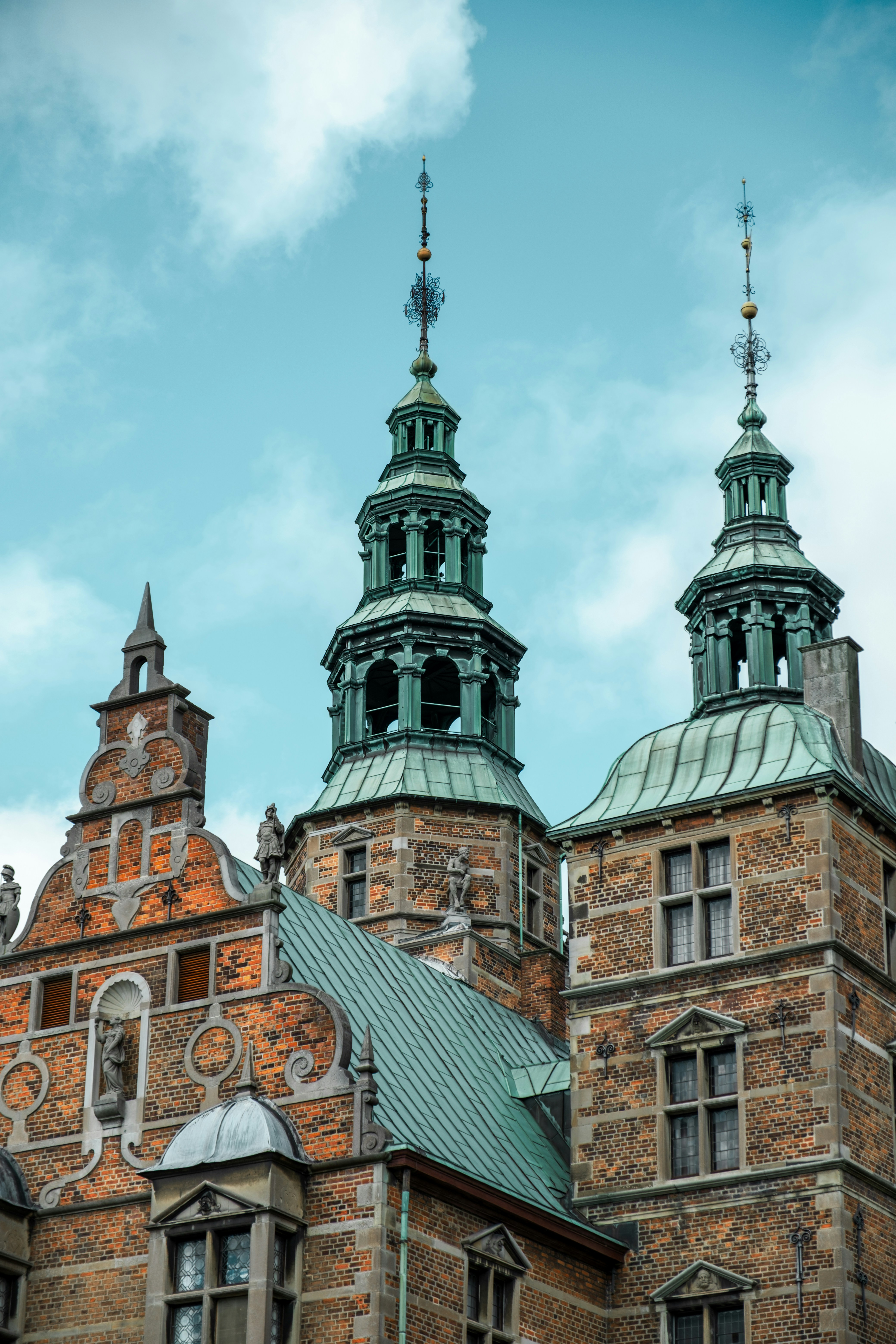 Twin Turrets Above Bricked Facades: A Gothic Revival Rooftop Against a Clear Sky