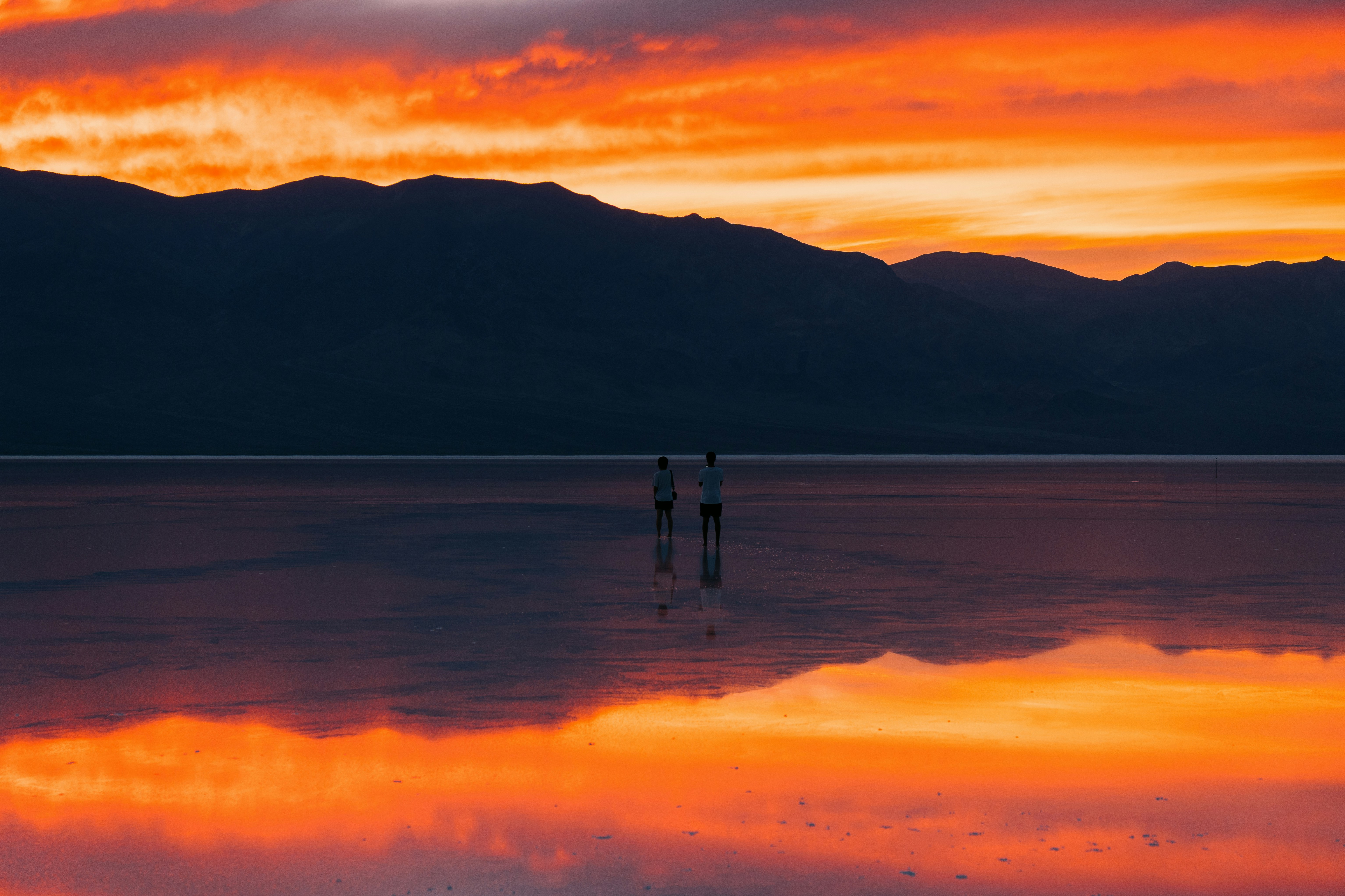 Silhouetted Figures on a Glassy Horizon at Sunset