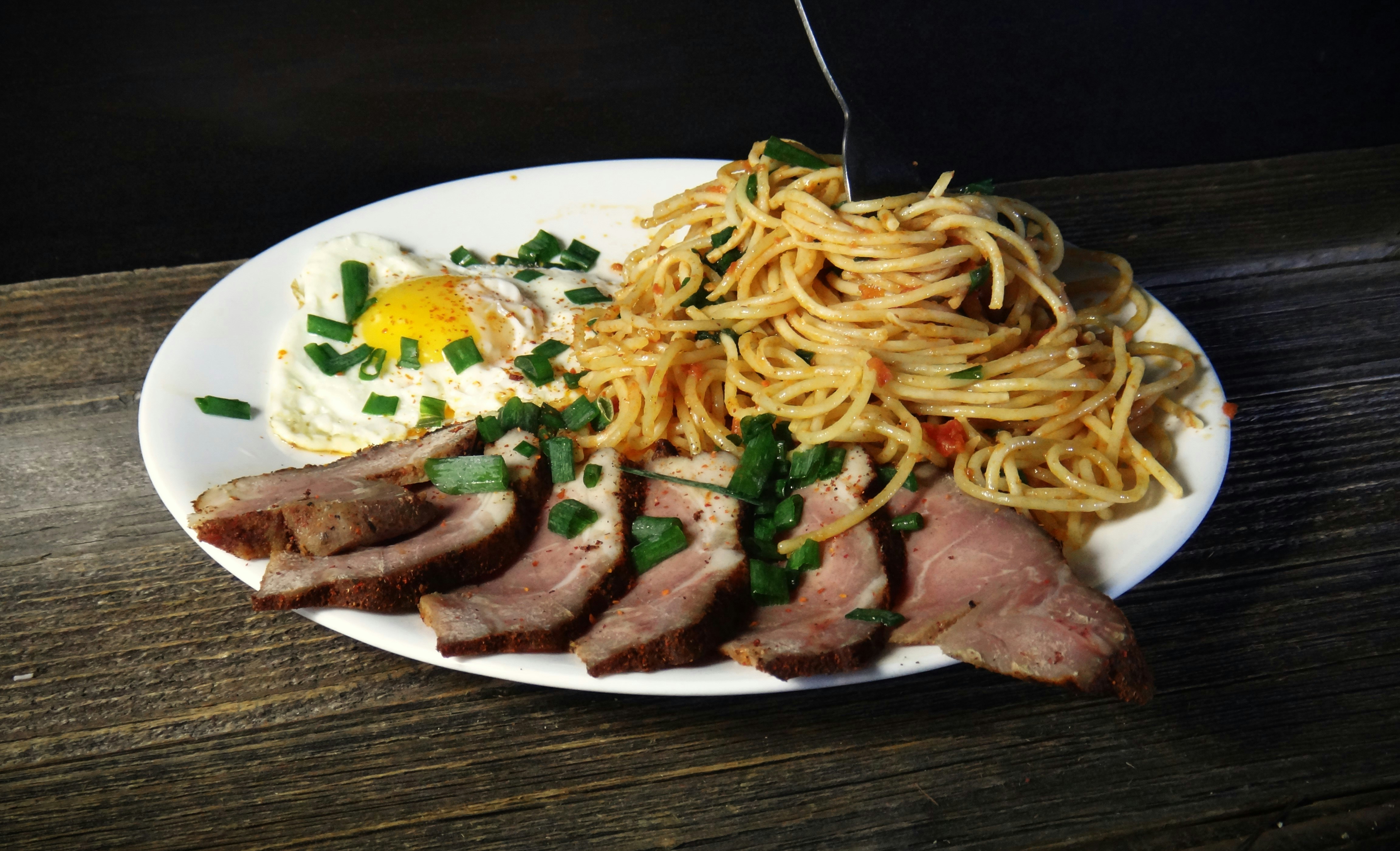 Carved Brisket and Egg Noodles: A Plate of Comfort On Rustic Wood